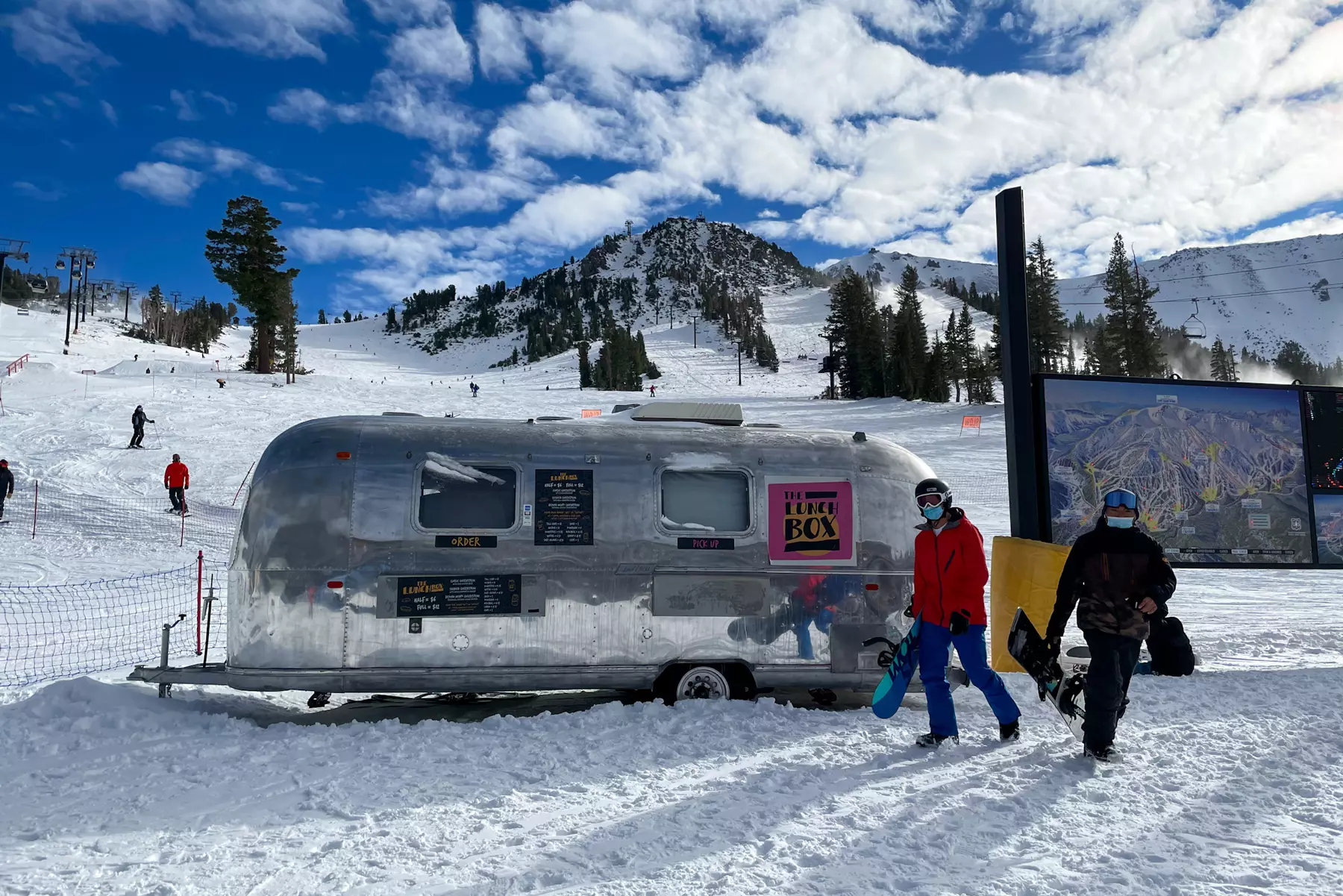 Két maszkot viselő snowboardos kint a Mammothnál