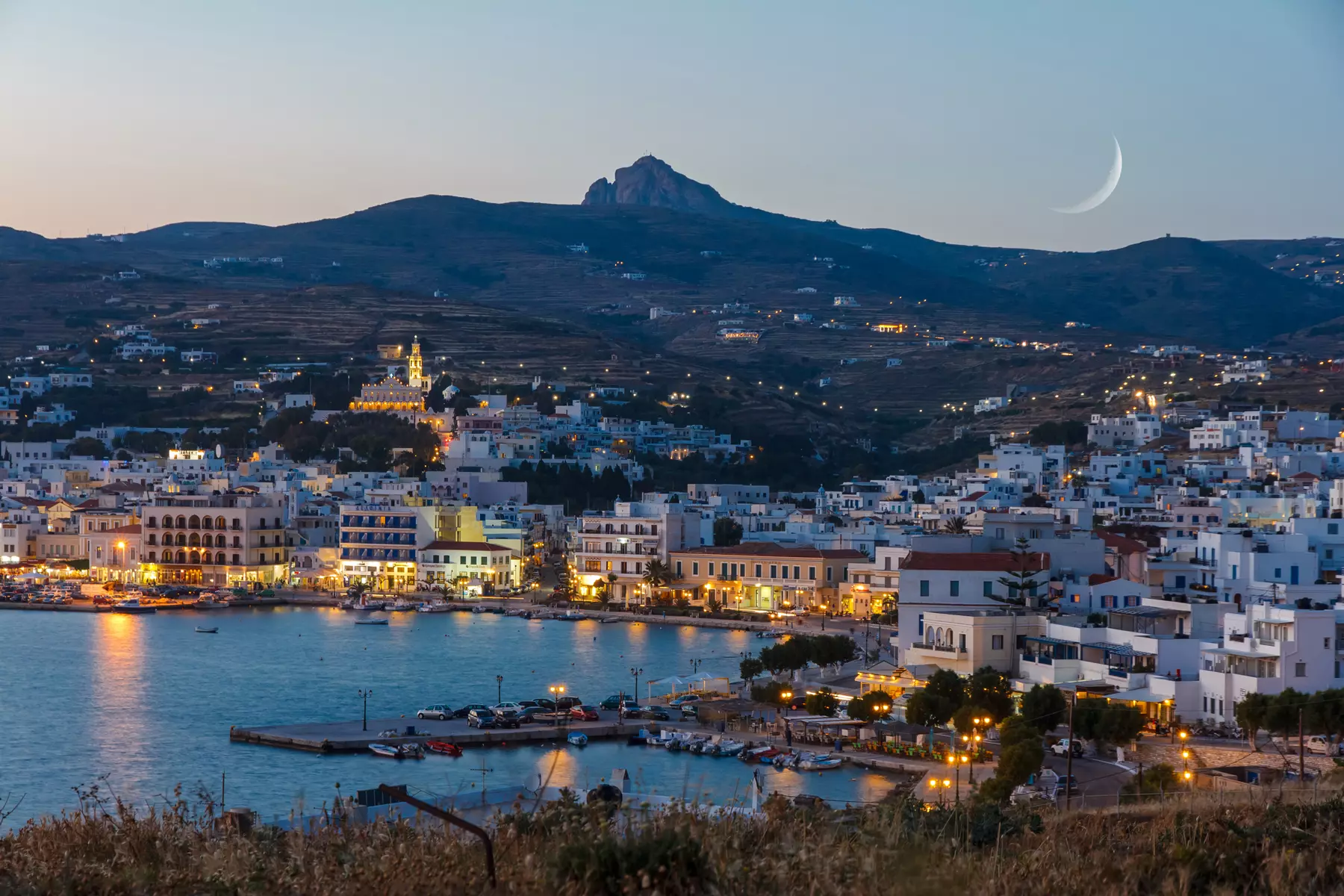 Tinos-eiland in Cycladen, Griekenland in de avond met maan die boven de hemel stijgt