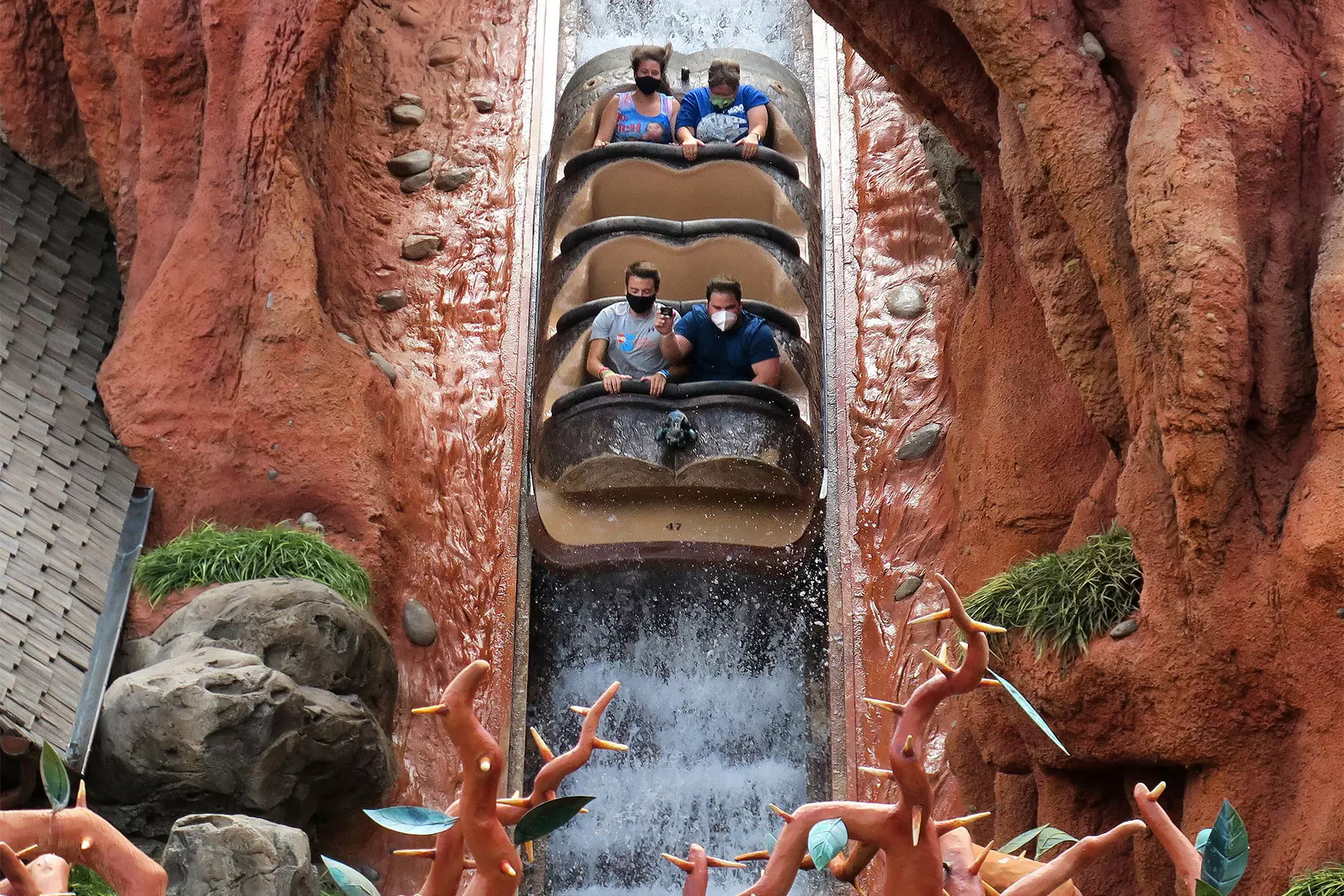 Pengunjung taman Disney mengenakan topeng di Splash Mountain