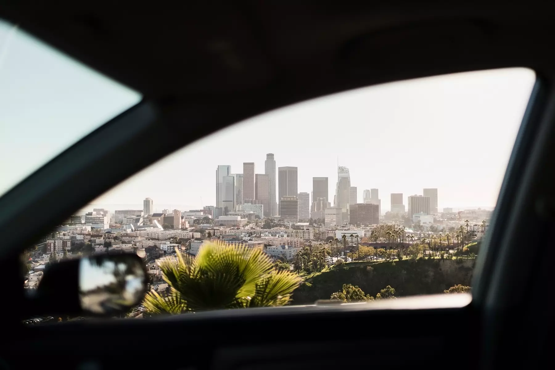 Ukubuka kwe-sunny cityscape out of car window, Los Angeles, California