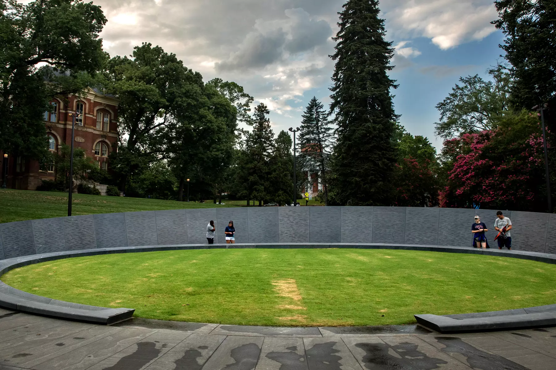 Vizitantoj ĉe la Universitato de Virginias Memorial por Sklavaj Laboristoj en Charlottesville, VA