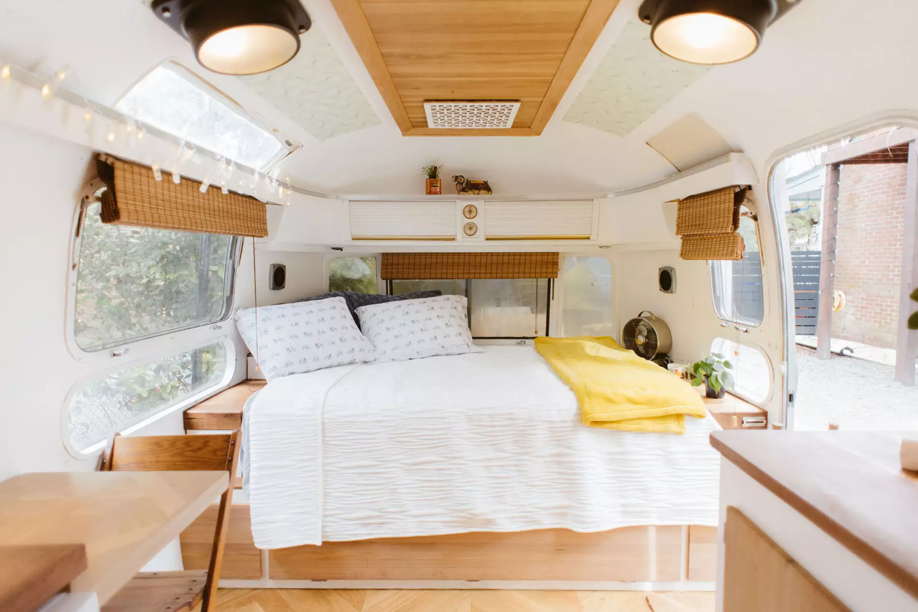 Tempat tidur dan aksen kayu di trailer Airstream