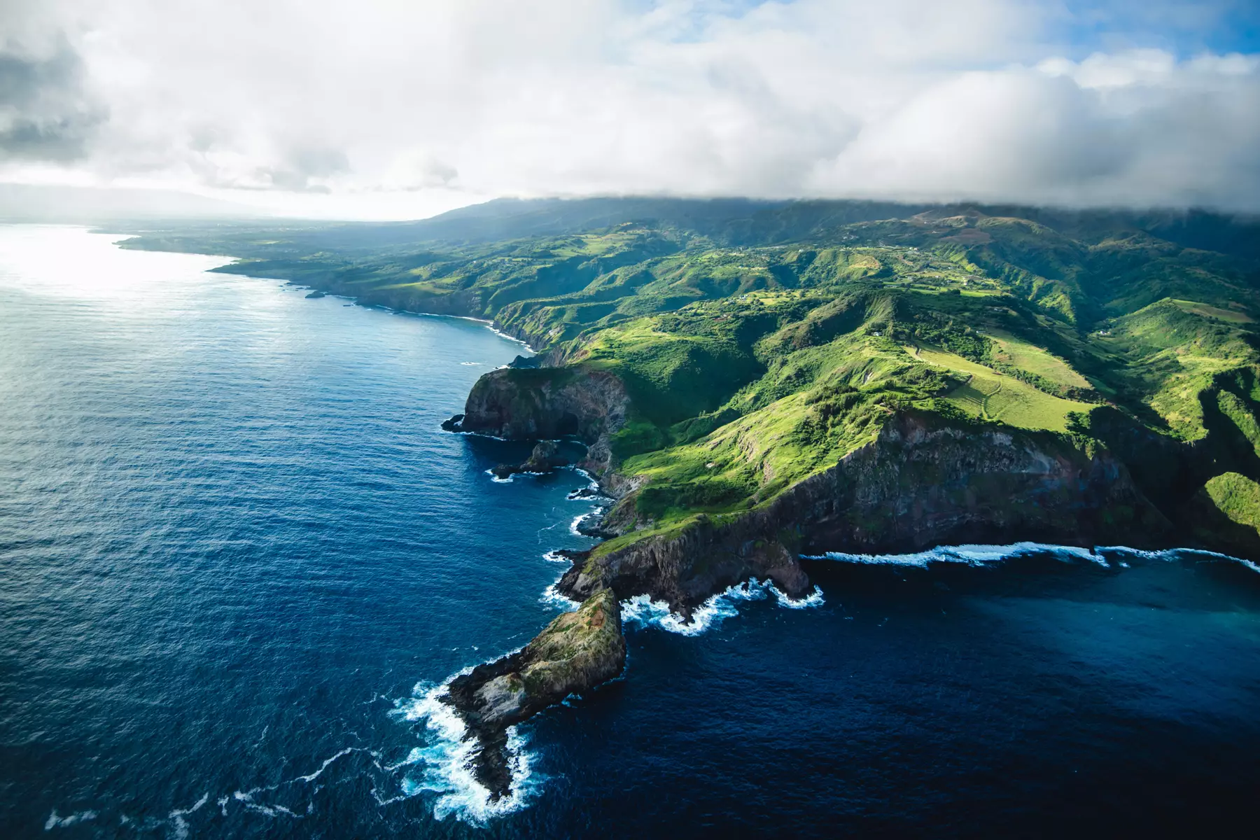 Letecký pohled na moře a hory proti obloze v Maui, Hawaii, Spojené státy americké