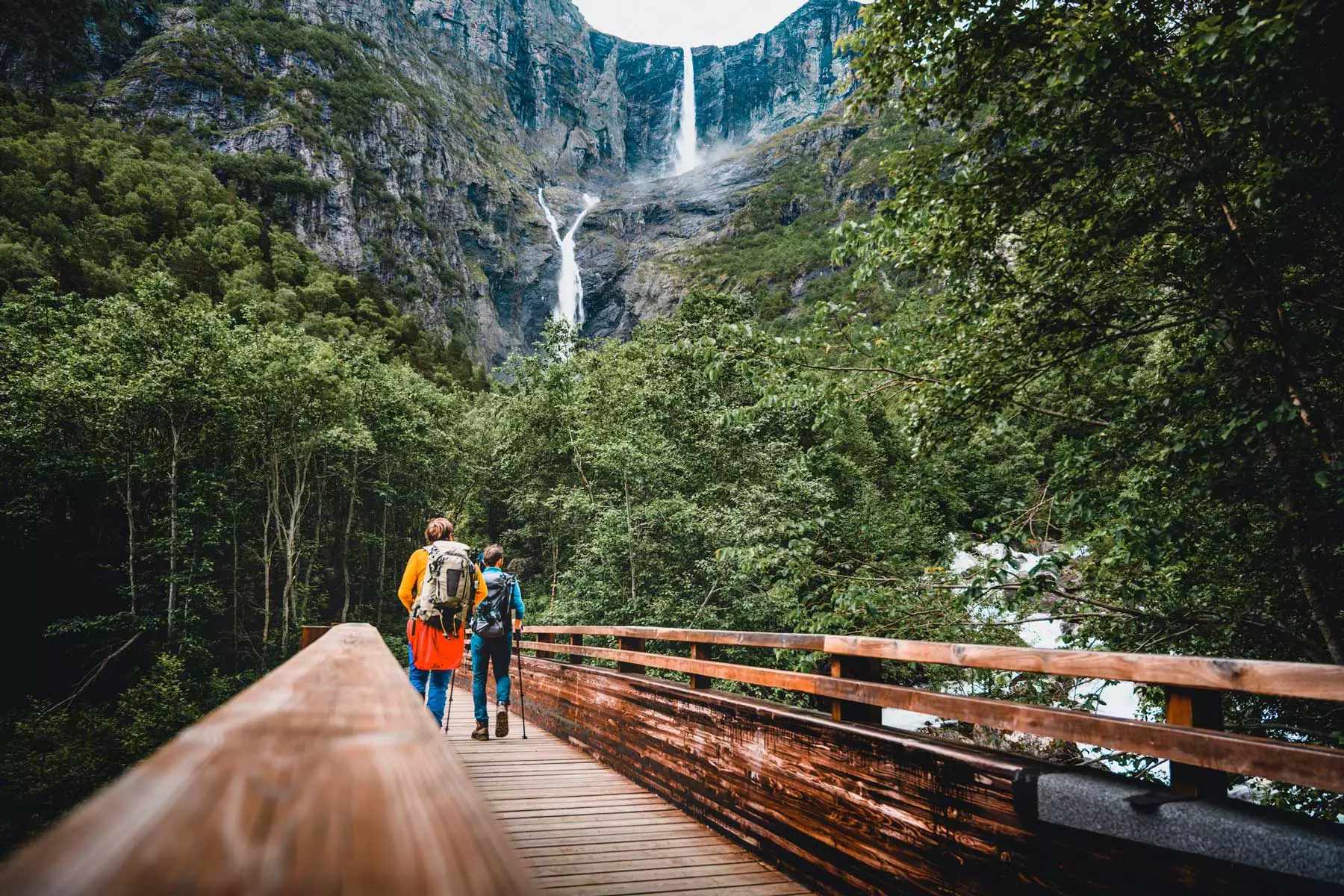 Menschen auf Holzbrücke wandern auf dem Weg zum Wasserfall Mardalsfossen, Norwegen