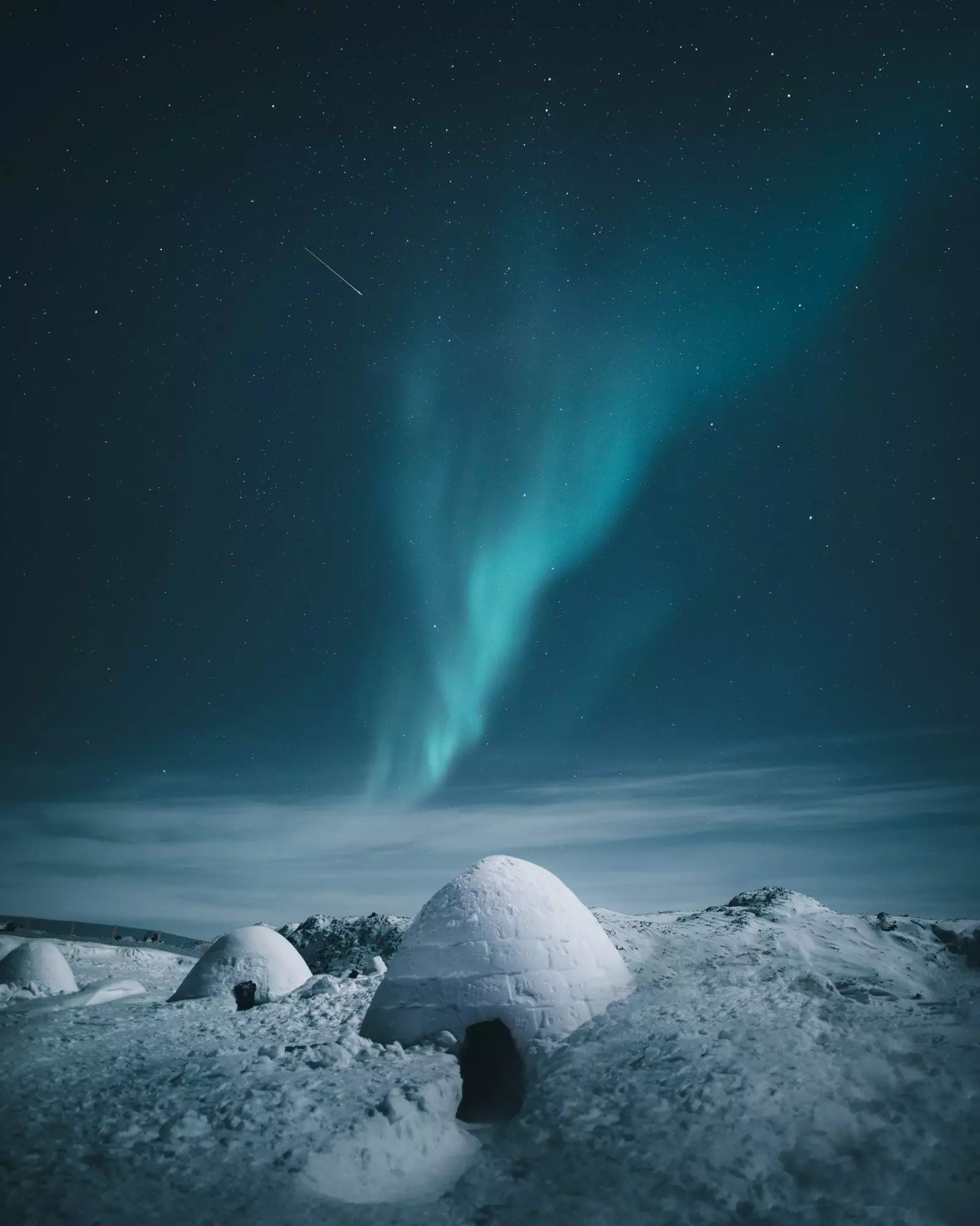 World of Greenland Iglood med norrsken på himlen