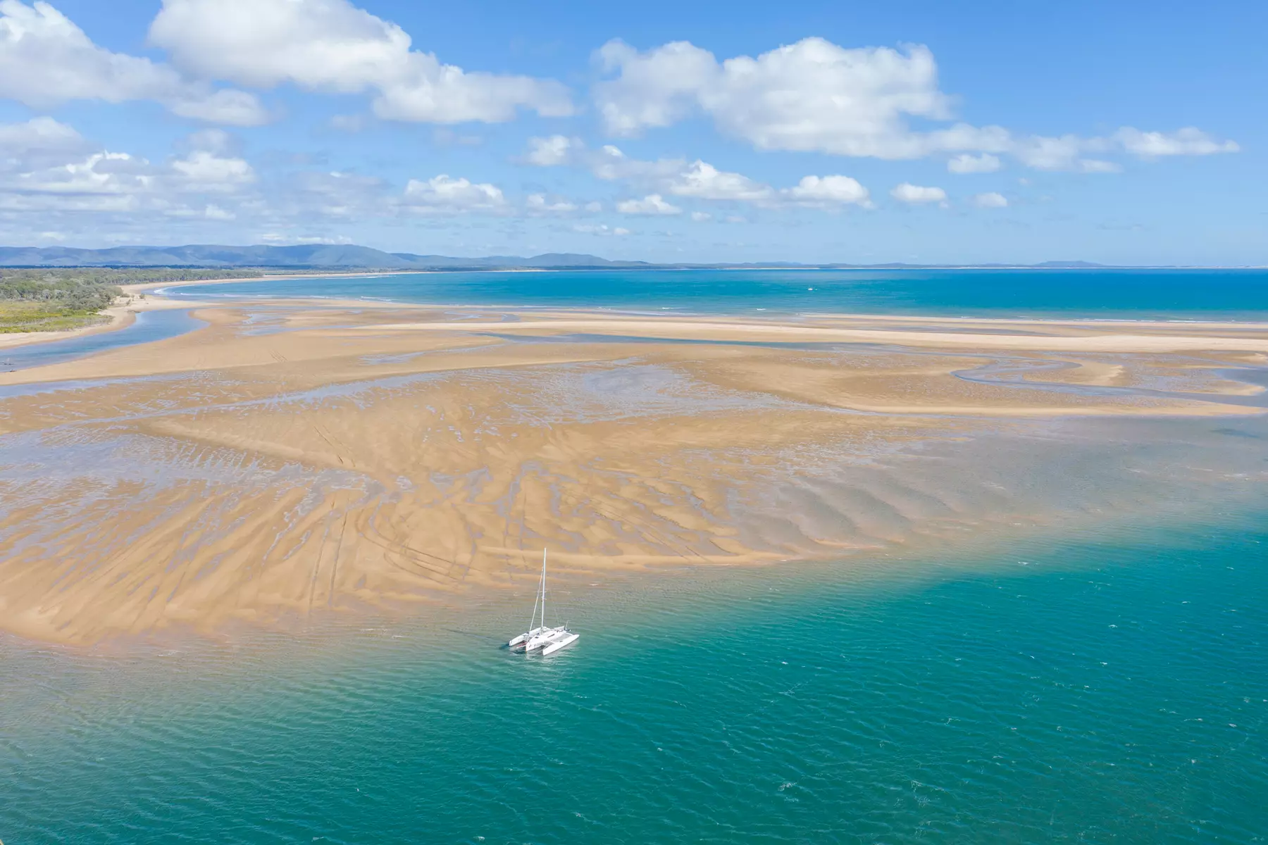 Punt de vista d'un drone sobre les aigües de l'oceà blau Aqua amb un sol iot amarrat per una barra de sorra, Seventeen Seventy, Austràlia