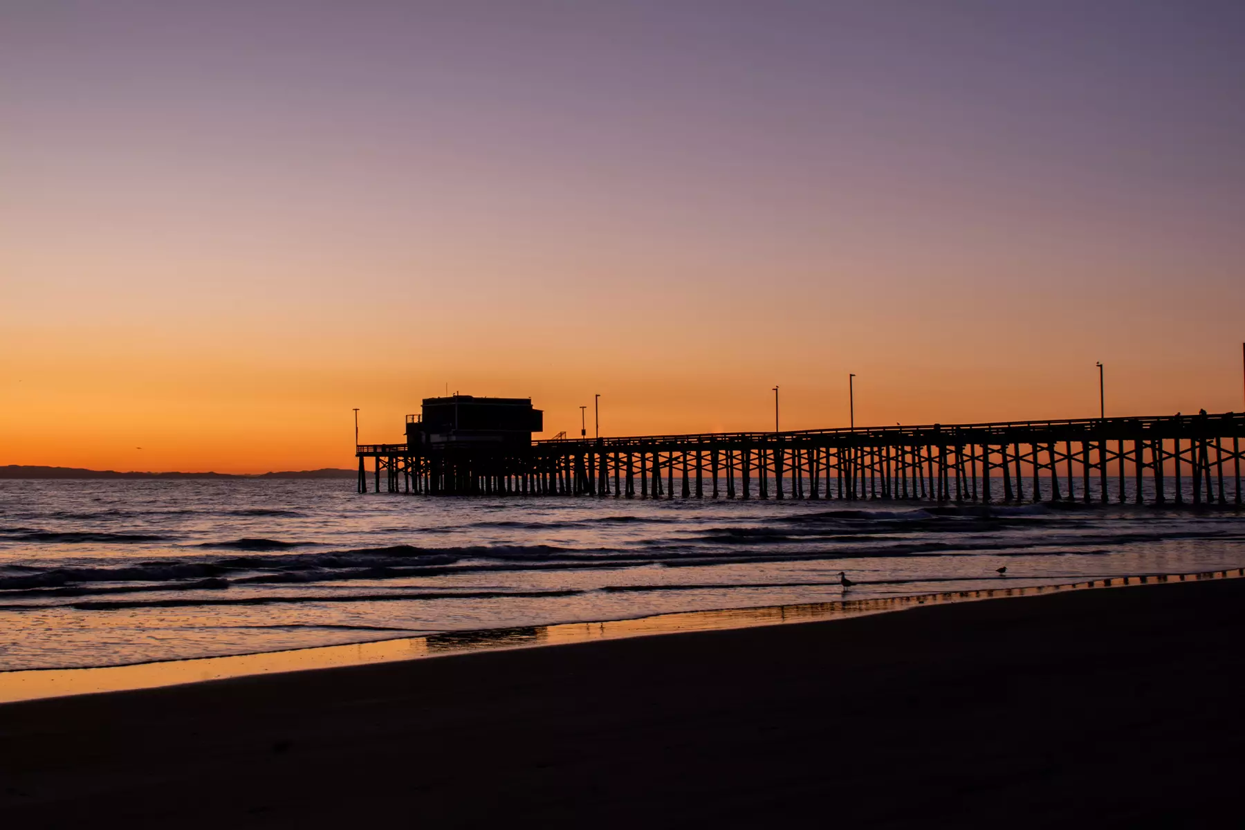 Talvine päikeseloojang Newport Beachis Californias Orange'i maakonnas muuli lähedal