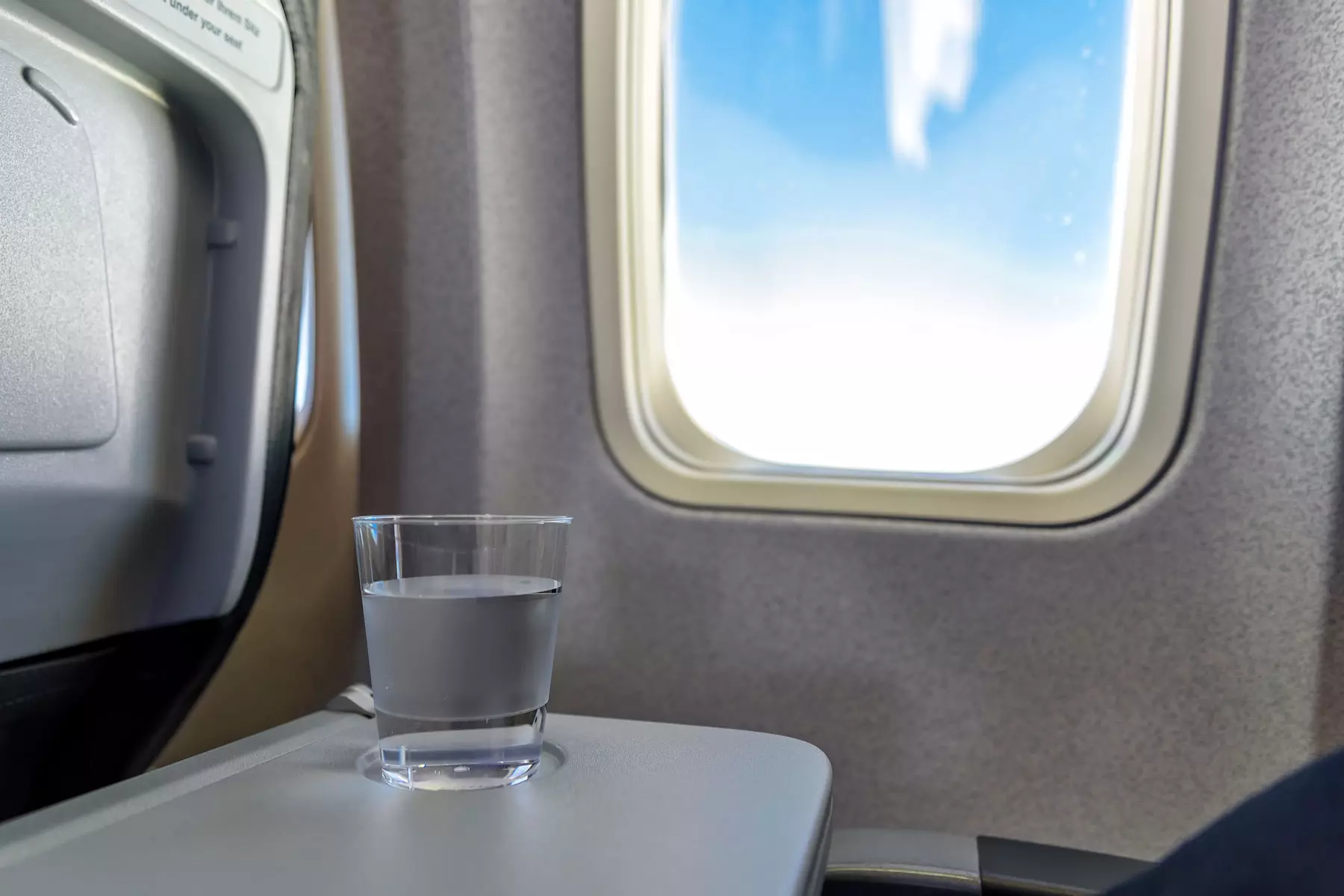 bicchiere d'acqua in un bicchiere su un tavolo vassoio di aeroplano