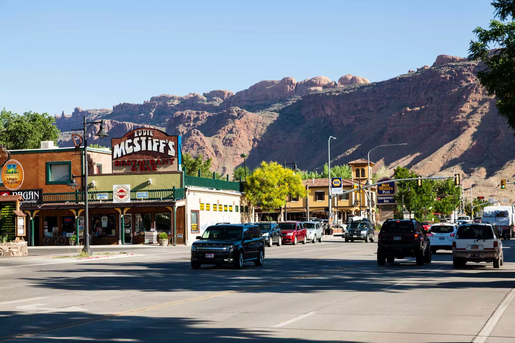 Butiksfronter, restaurantskilt og gadetrafik ved Main Street i Moab, Utah