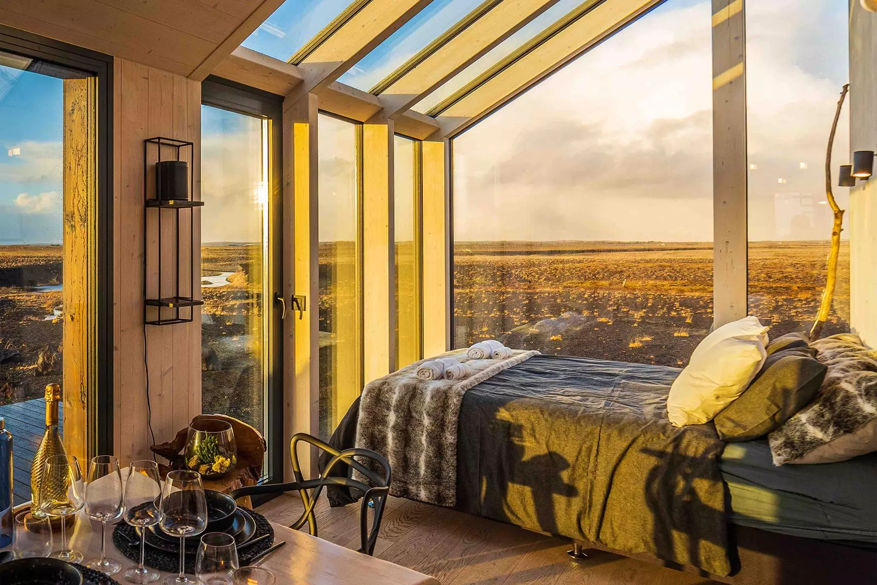 La cama y la vista desde el interior de la casa de cristal en Islandia