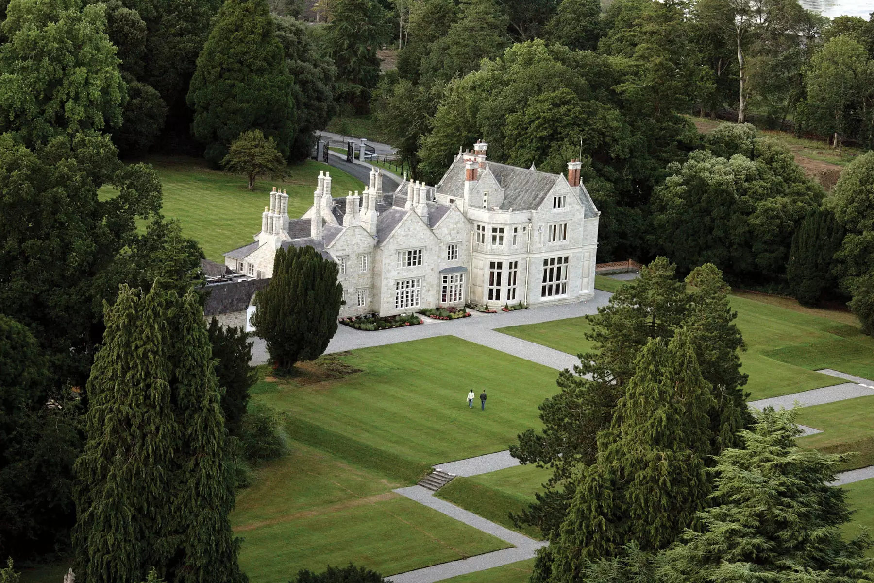 Aerial view sa mga tawo nga naglakaw padulong sa Lough Ryan Castle sa dagat nga lunhaw