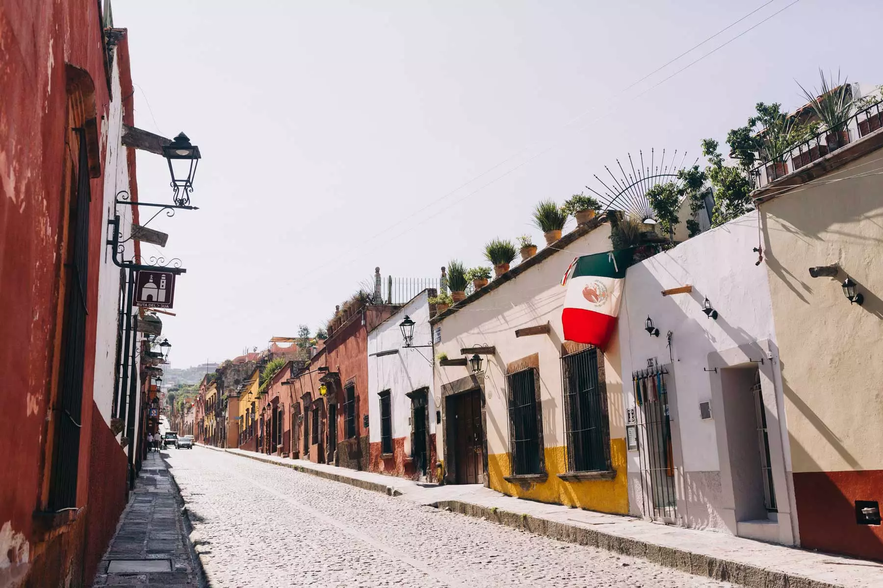 San Miguel de Allende ýaşaýyş köçesindäki jaýdan Meksikanyň baýdagy uçýar