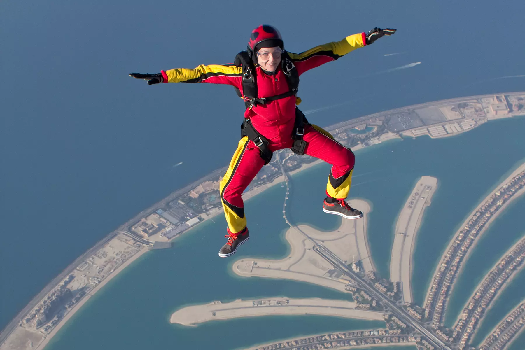 Skydiving virino libera fluganta super Dubaja palmo