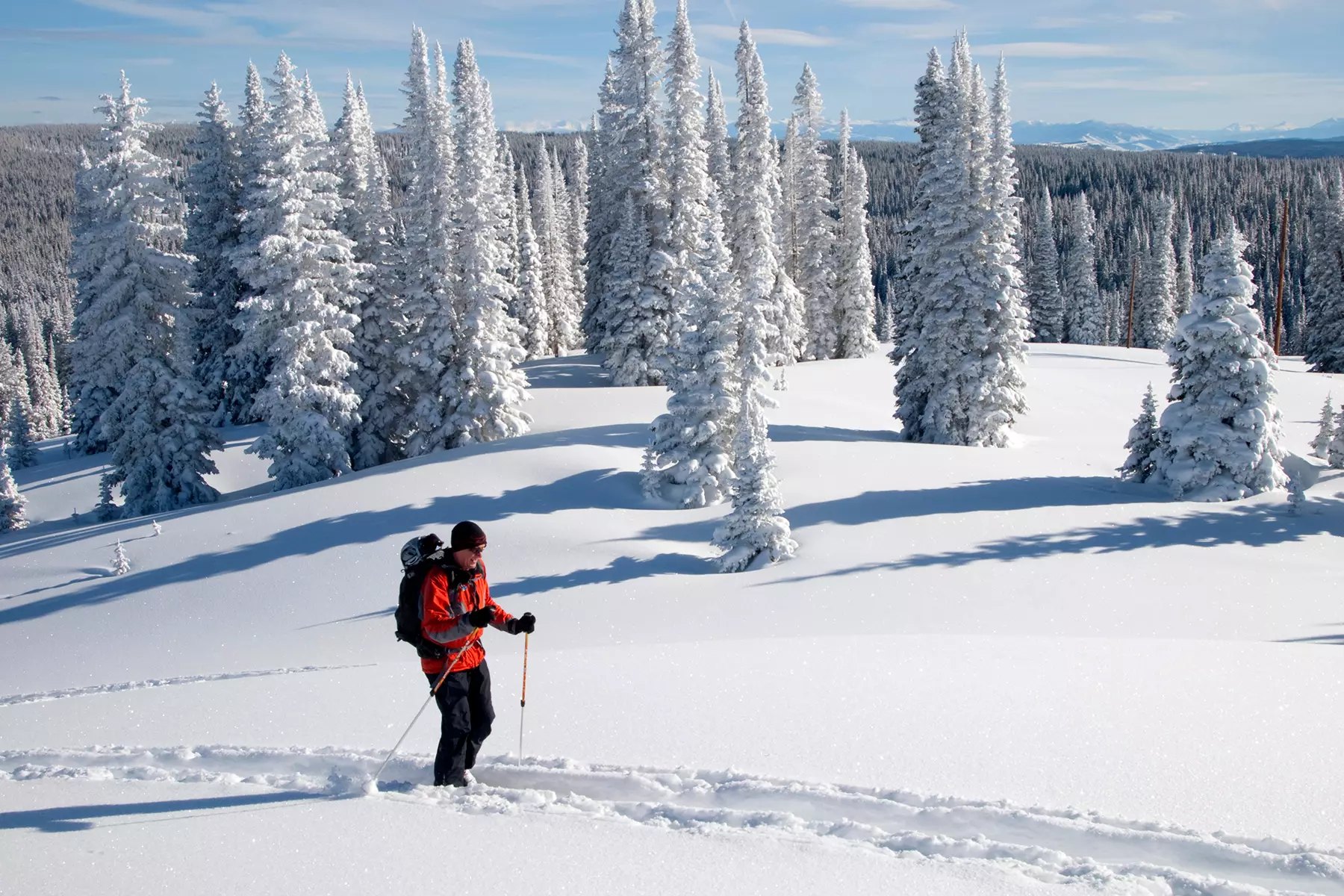 ผู้ชายกำลังปีนเขาบนภูเขาที่ปกคลุมด้วยหิมะใน Steamboat Springs