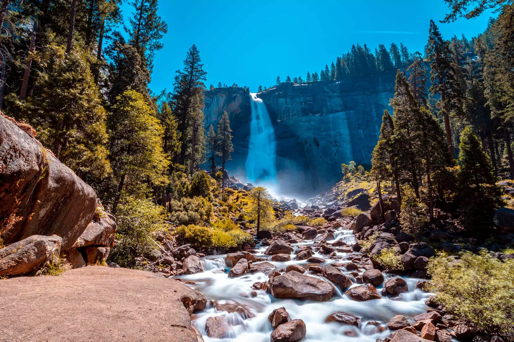 التعرض الطويل في Vernal Falls من الأسفل في صباح أحد أيام الصيف والشمس من فوق.