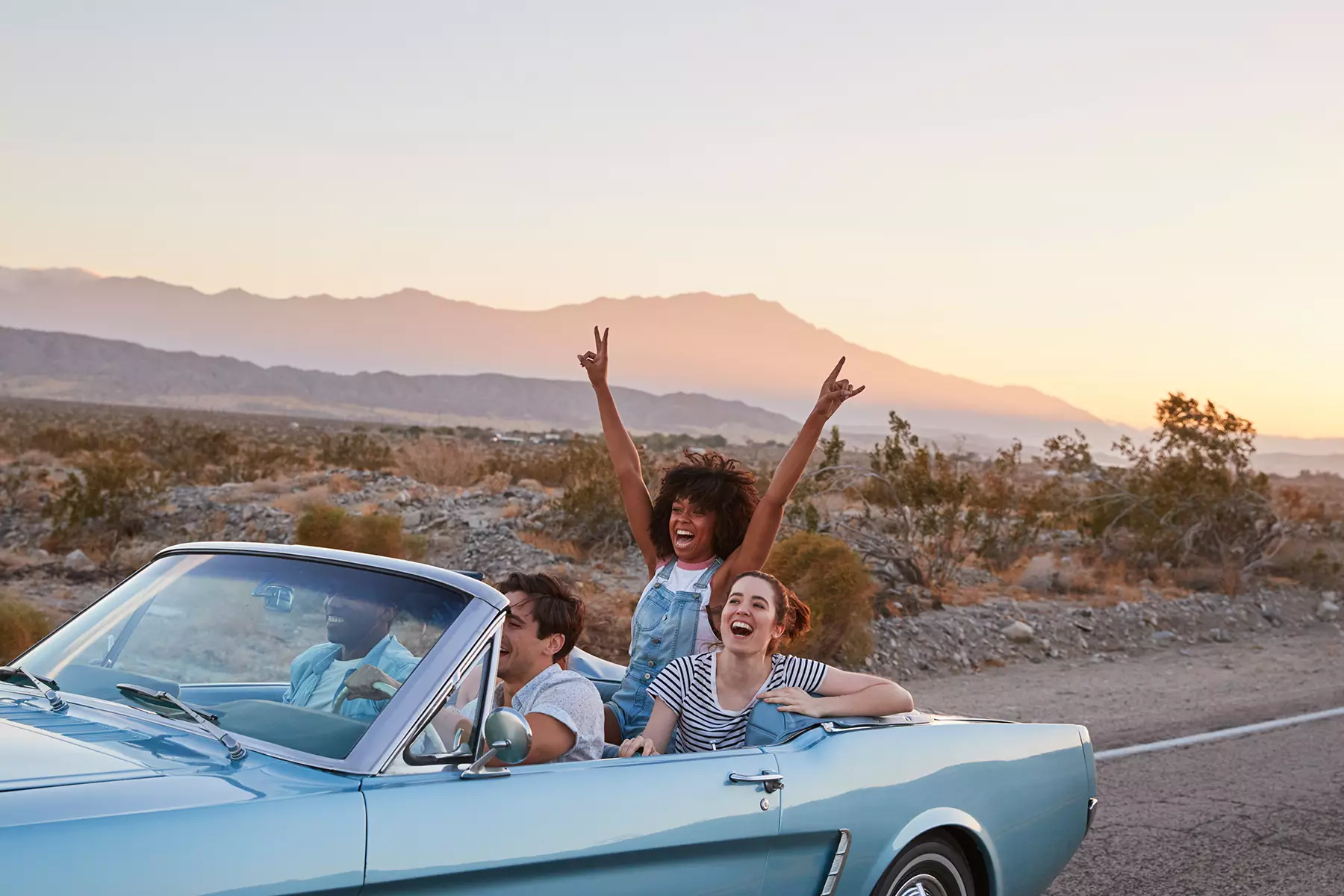 Gruppe af venner på roadtrip, der kører klassisk cabrioletbil