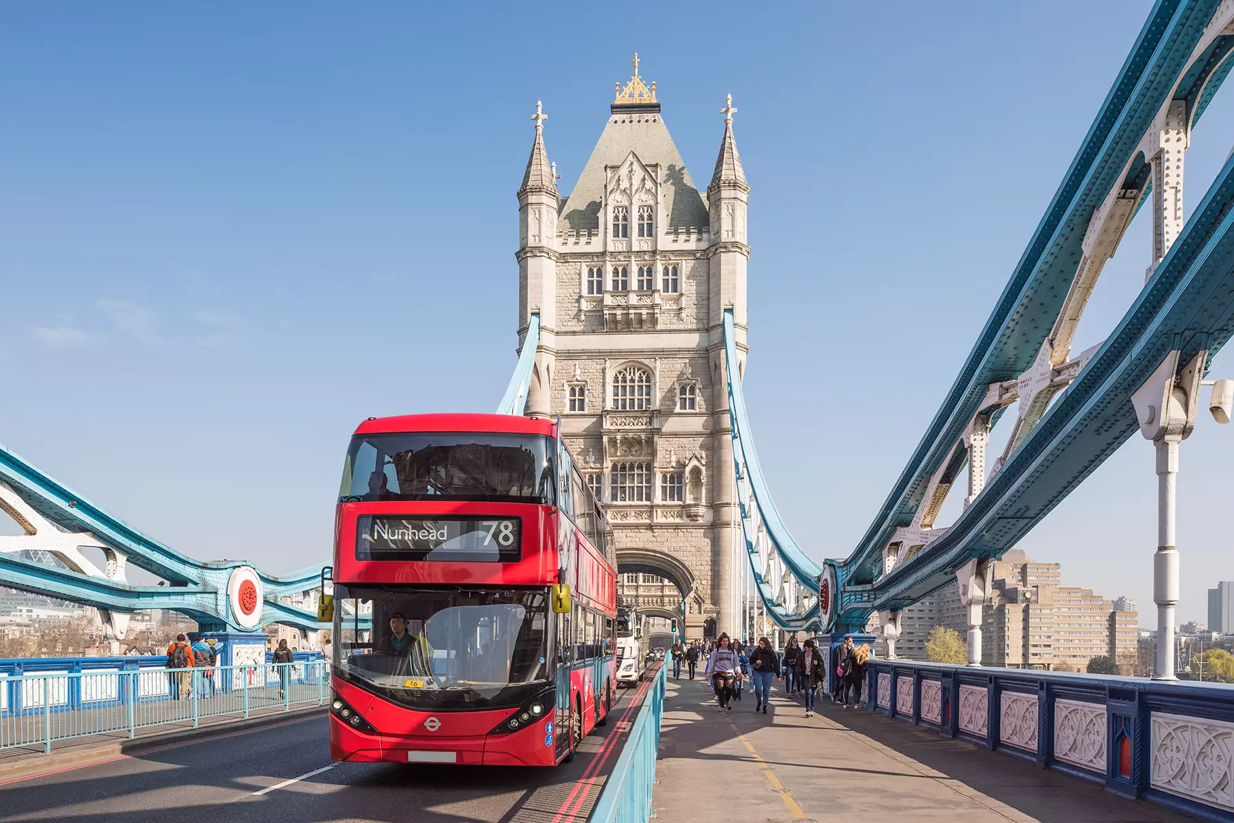 Tower Bridge арқылы өтіп бара жатқан қызыл автобус