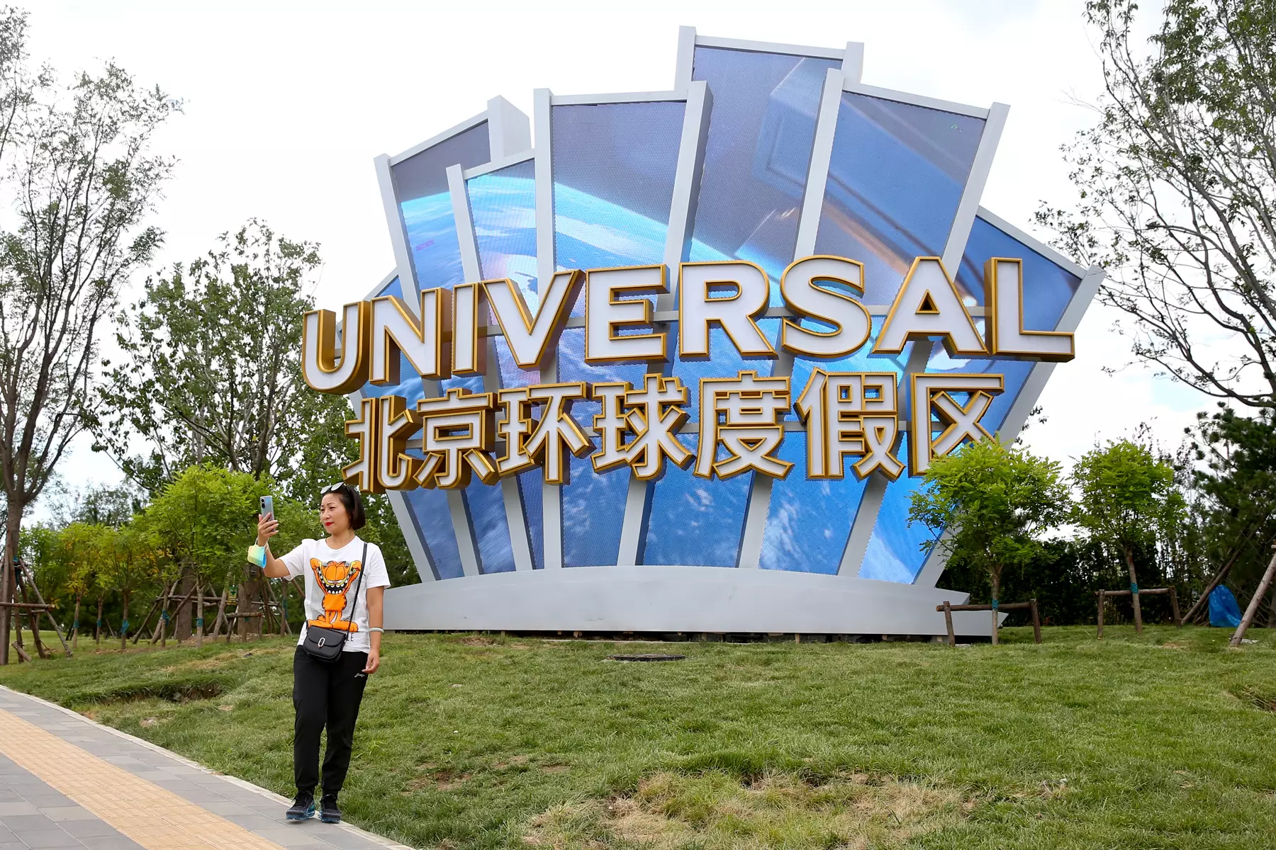 Žena si robí selfie pred nápisom v Universal Beijing Resort 25. augusta 2021 v Pekingu v Číne