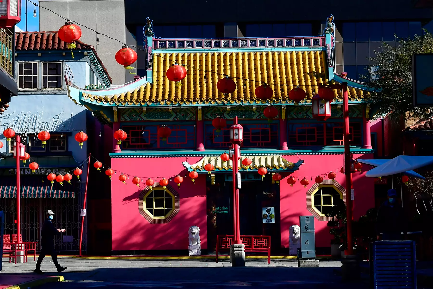 En fotgjenger med ansiktsmaske går gjennom Chinatown Central Plaza på den første dagen av oksens månenyttår i Los Angeles