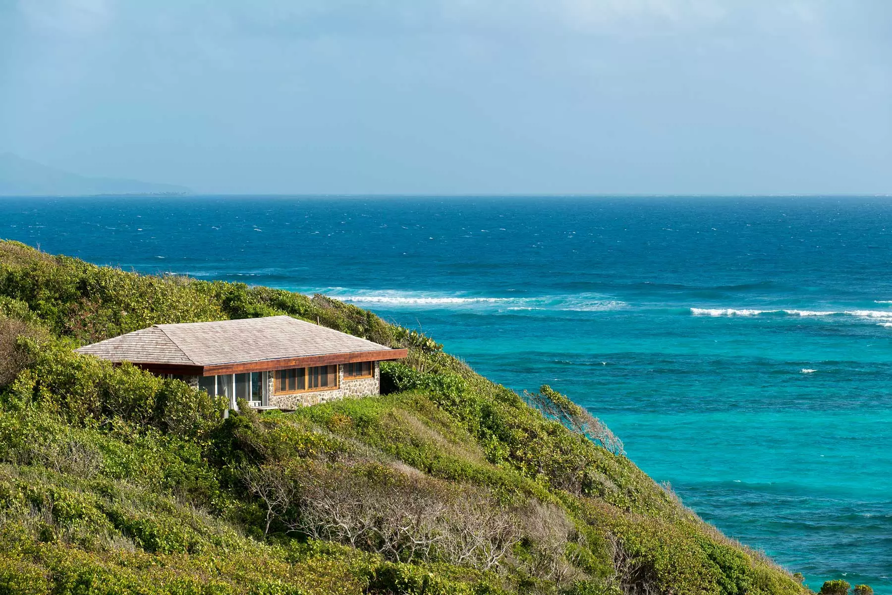 Una casa de camp del complex Petit St Vincent es troba en un turó, amb aigües turqueses a sota