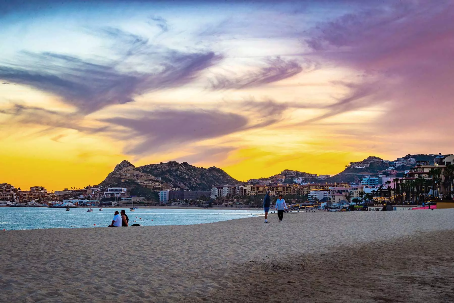 Oszałamiający fioletowy, niebieski i żółty zachód słońca nad plażą w Cabo San Lucas w Meksyku