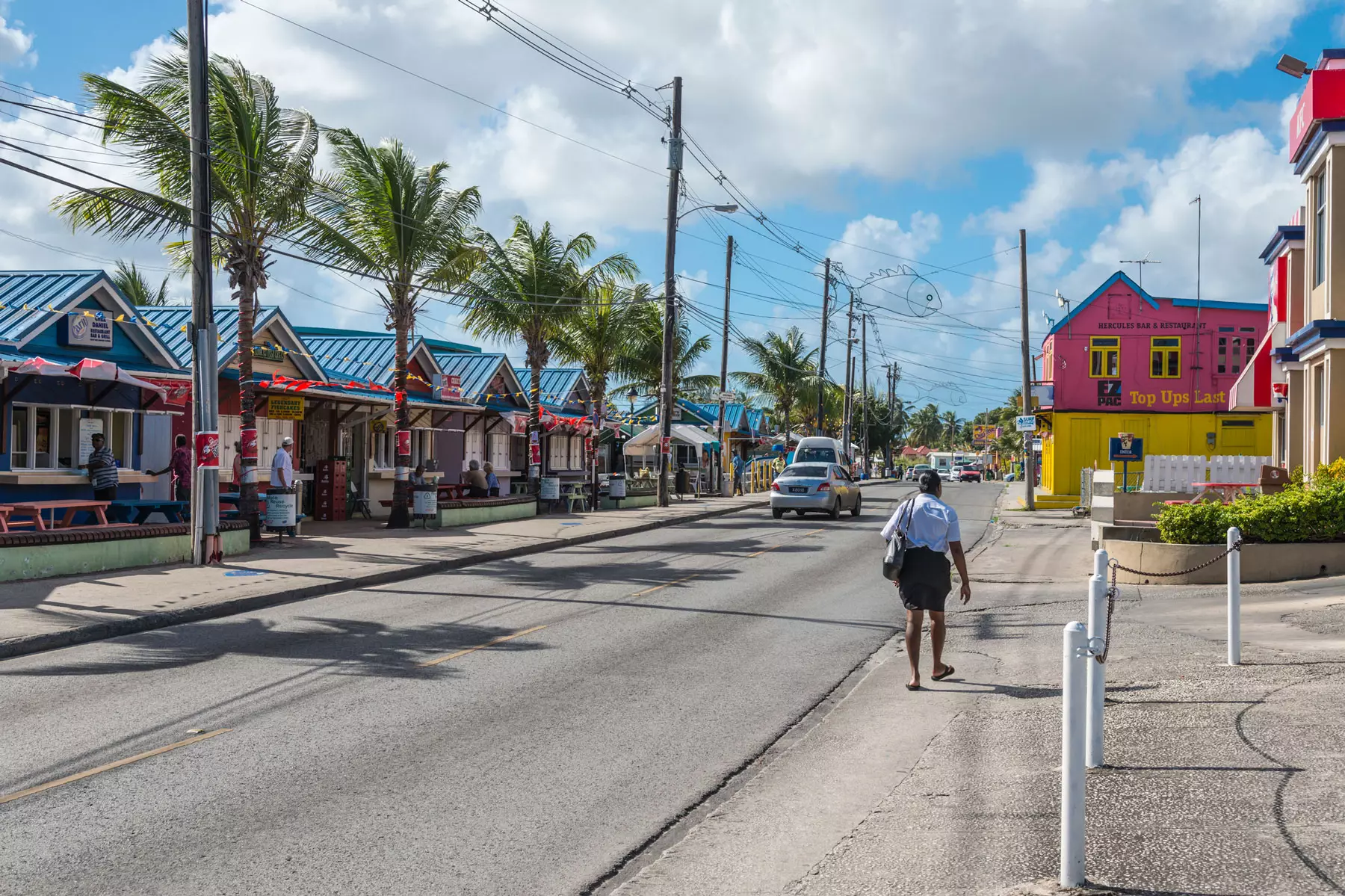 Lokale dame die door de hoofdstraat van het vissersdorp Oistins loopt, aan de zuidkust van het Caribische eiland Barbados