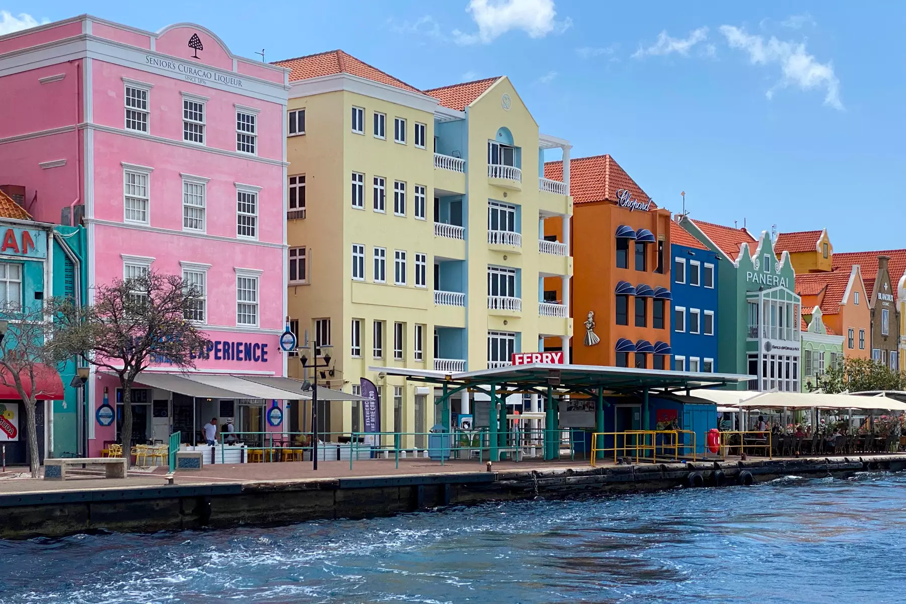 pastellfargede kolonibygninger ved vannkanten av gamlebyen Willemstad, Curacao