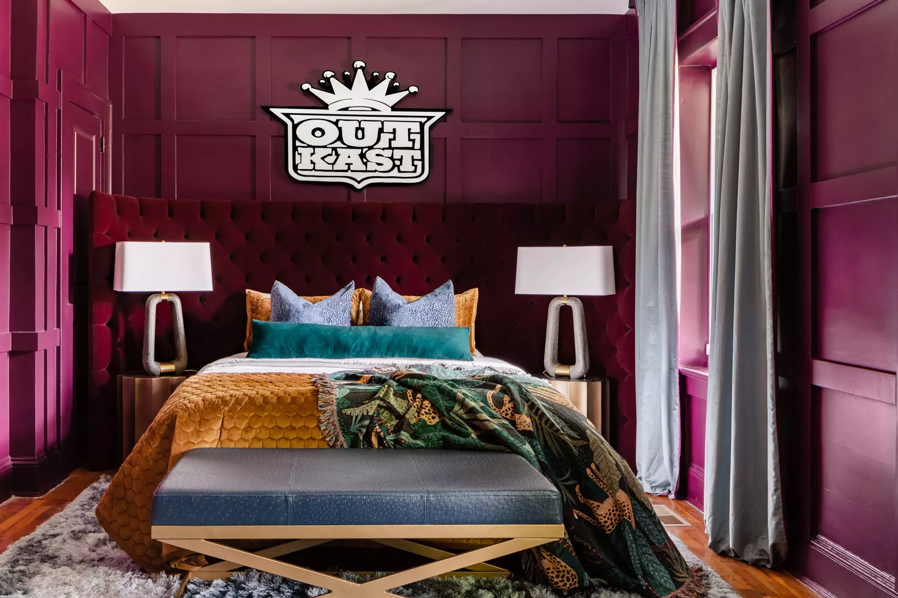 Quarto da Dungeon Family House com o logotipo do Outkast acima da cama