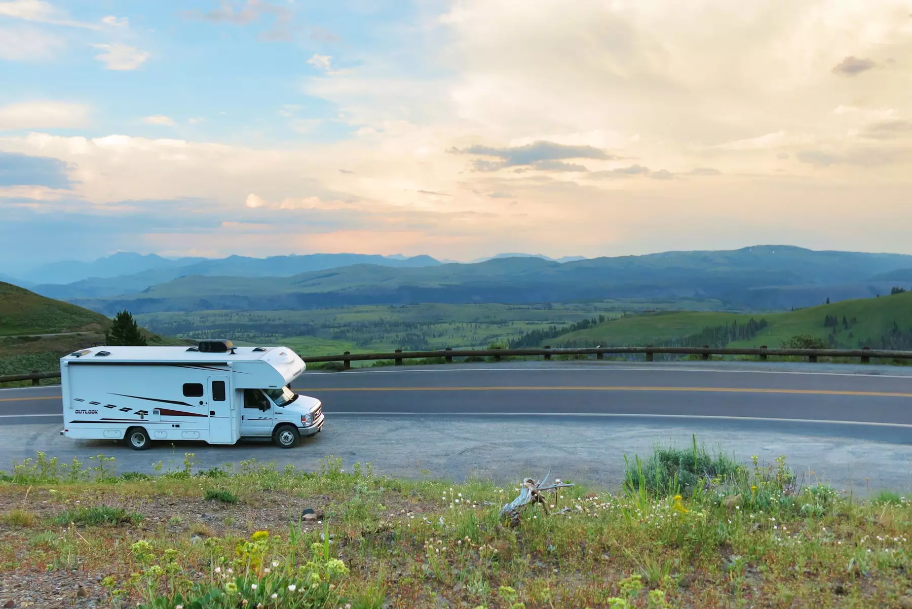 Weißes Miet-Wohnmobil, das am Rand einer windigen Straße mit unglaublicher Aussicht im Yellowstone-Nationalpark geparkt ist