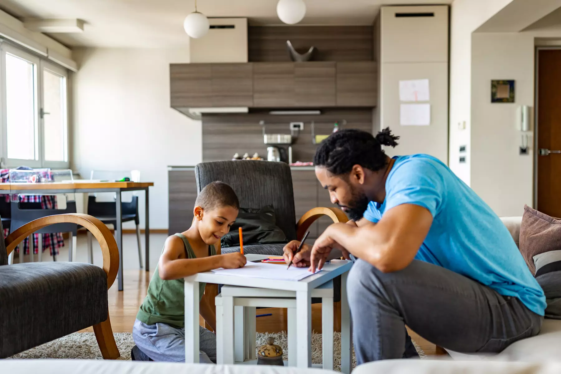 Pai desenhando com filho em casa