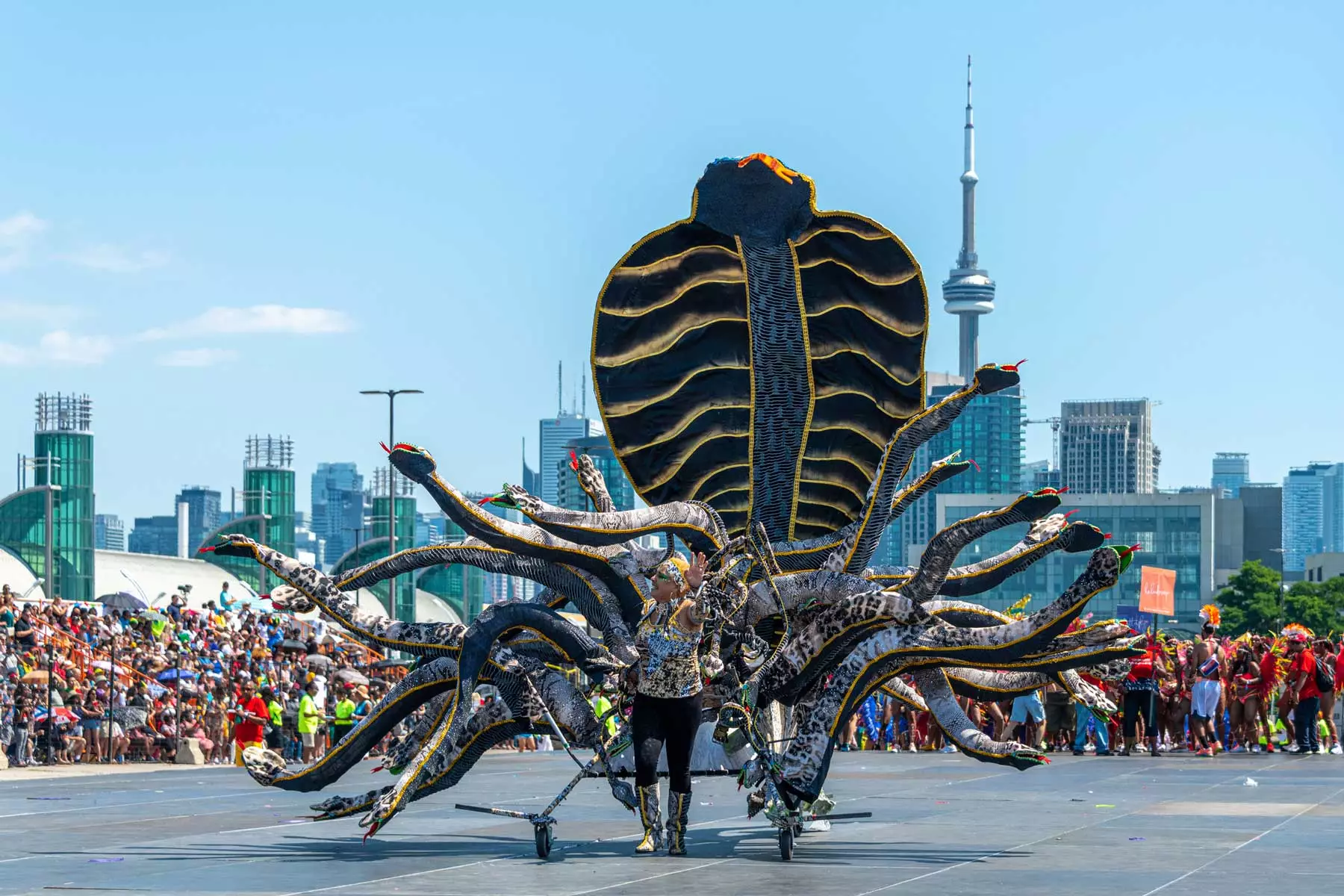 Osoba, která táhne malý plovák během zahajovacího ceremoniálu festivalu Caribana.