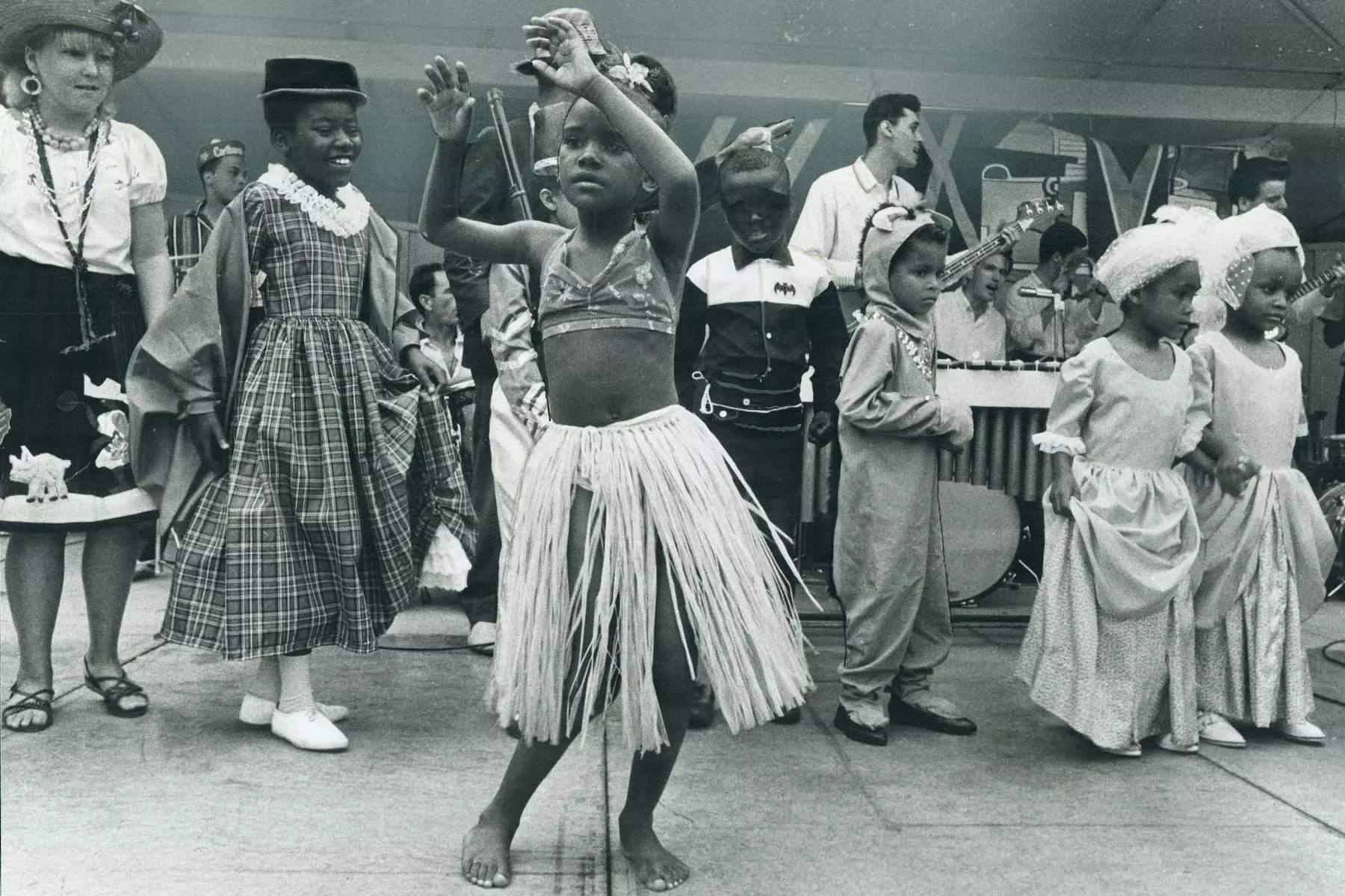 Dítě v sukni z trávy pohupující se v rytmu calypso kapely; Chandra Galasso; 7; byl jedním z 10 mladých tanců včera na festivalu Caribana '67 na Center Island. Projekt stého výročí kanadské Západní Indie se zúčastnily tisíce lidí