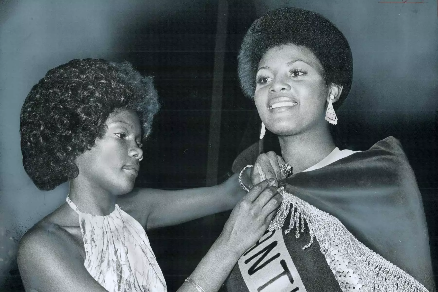 Miss Caribana inizia il suo regno; Junie Samuel; una dattilografa di 19 anni di Antigua; è vestito con il mantello cremisi di Miss Caribana '72 ieri sera dalla signora Nolan Pitt; che ha regnato sul festival caraibico dell'anno scorso.