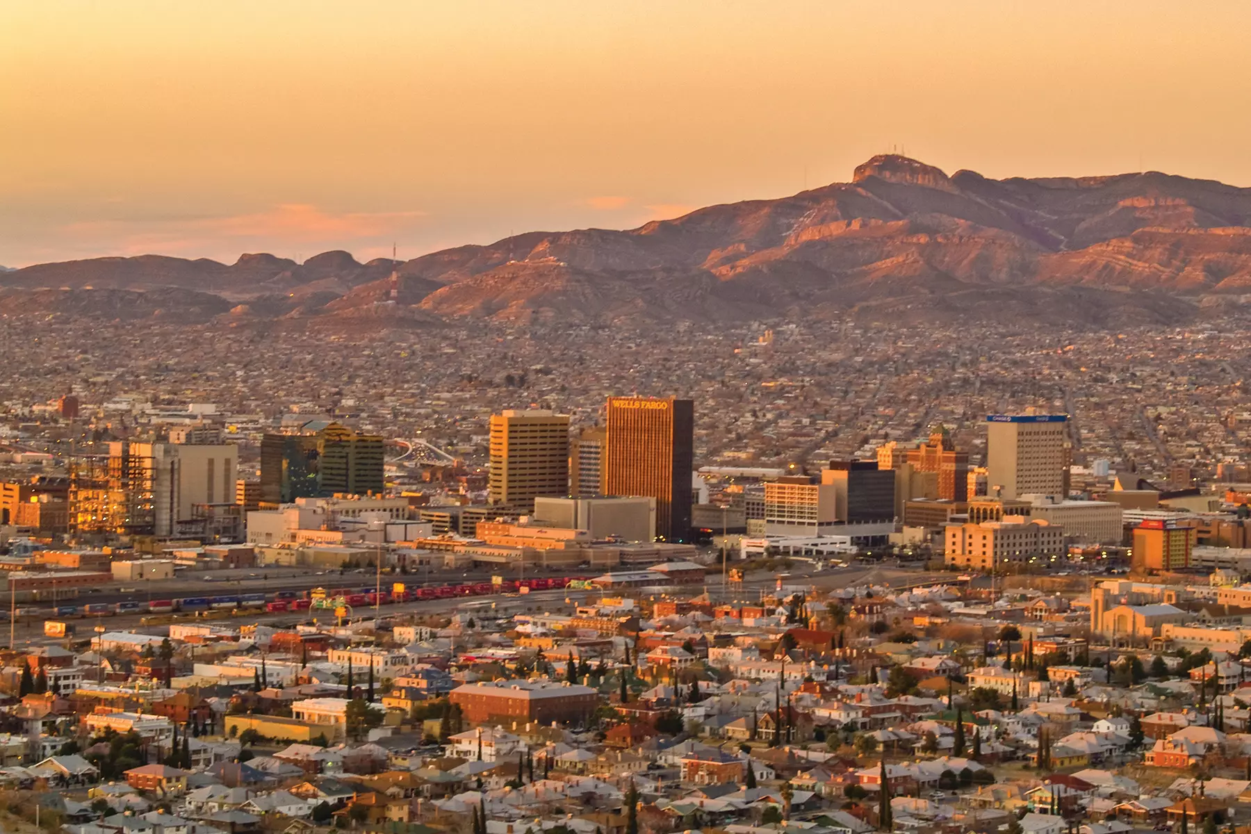 El Paso und Juarez werden durch das natürliche sanfte Licht unter einem wunderschönen orangefarbenen Himmel beleuchtet