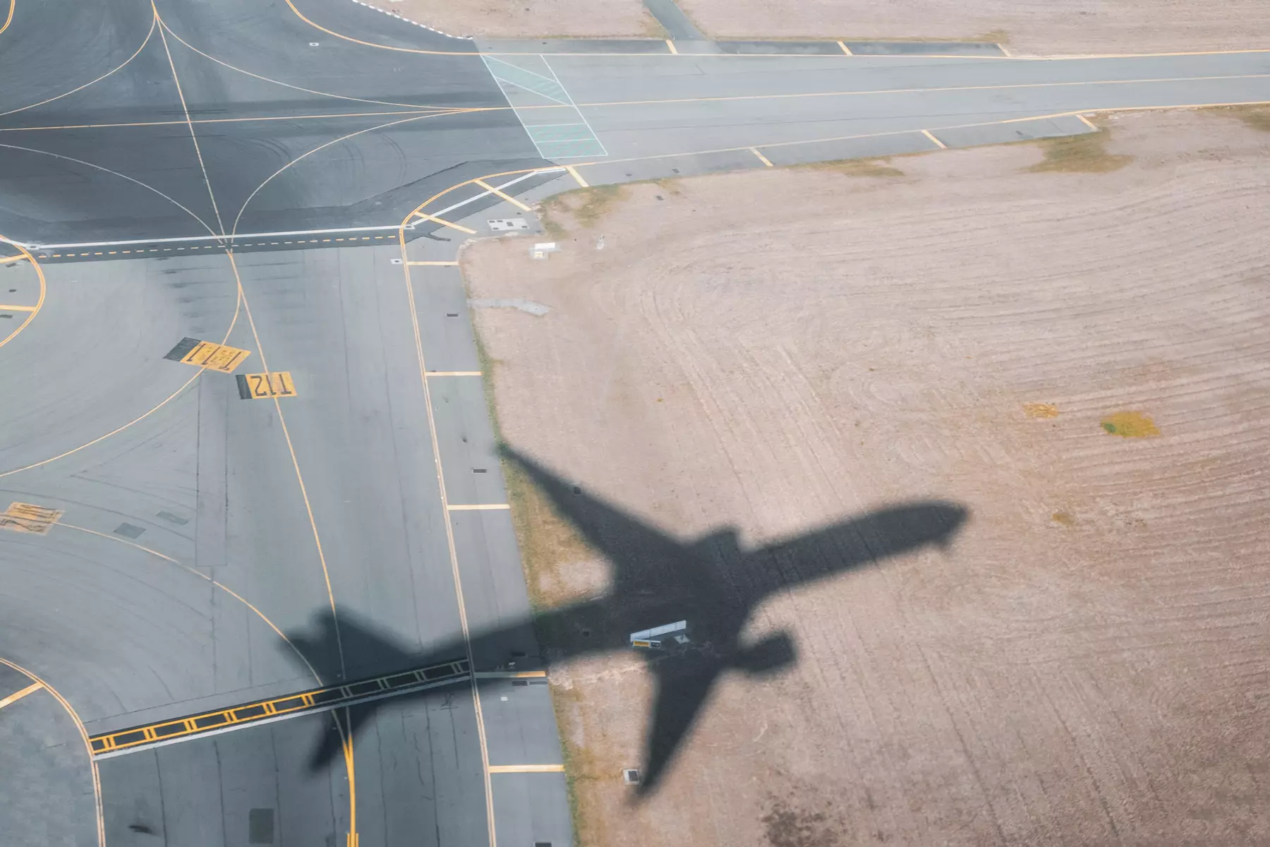 Schatten des Flugzeugs, das vom Flughafen abhebt