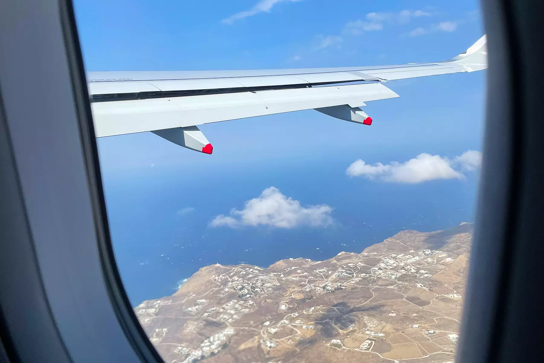 Kijkend uit een vliegtuigraam boven Mykonos