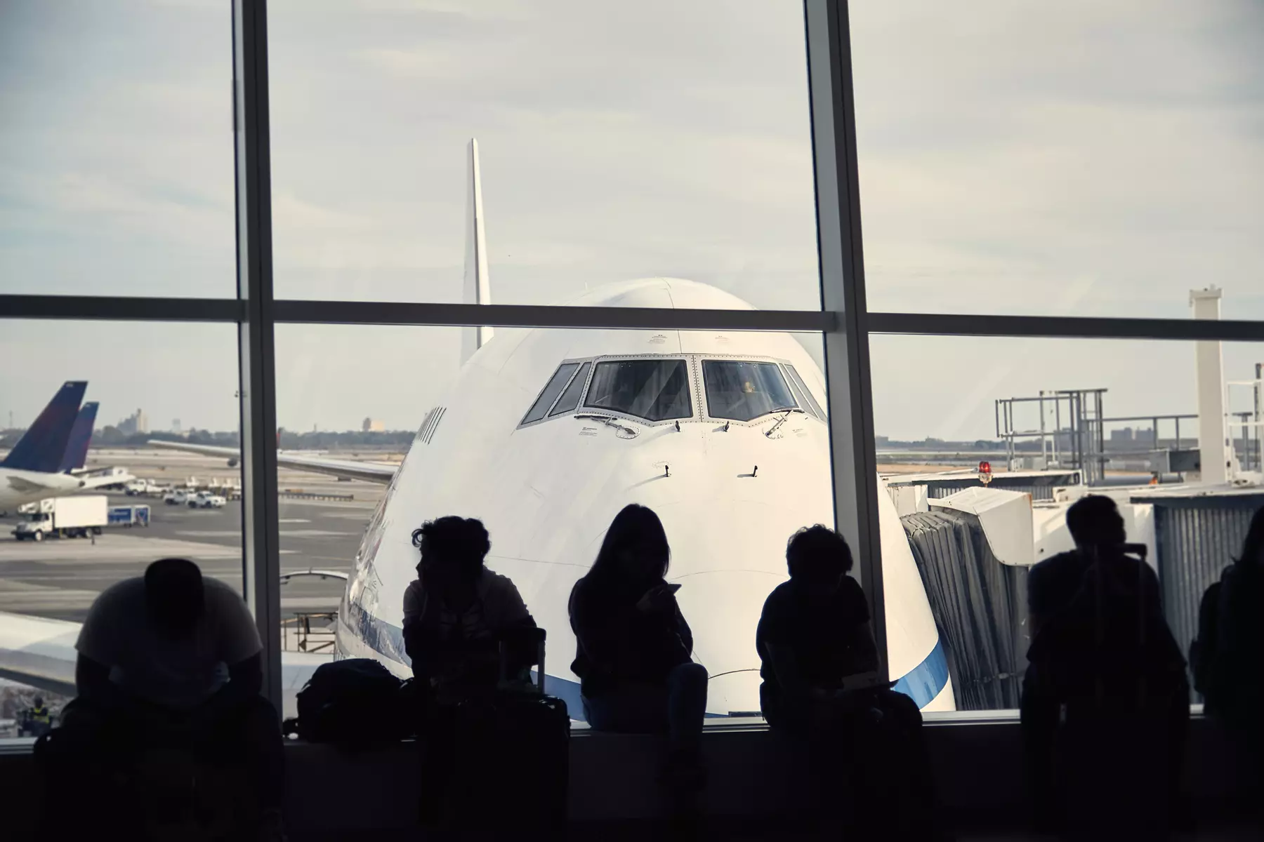 승객들이 공항 터미널에서 출발하는 상업용 비행기에 탑승하기 위해 기다리고 있습니다.