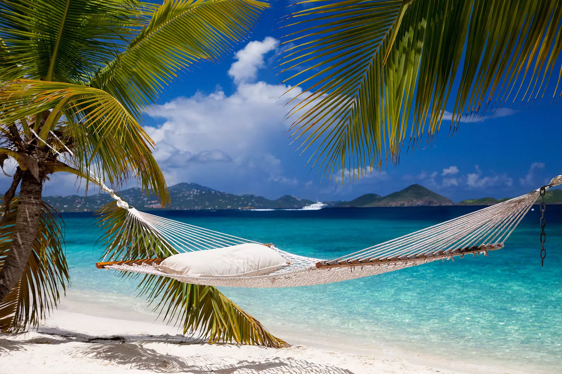 Hängematte gestreckt tëscht Palmen op enger Plage, St.John, USVI