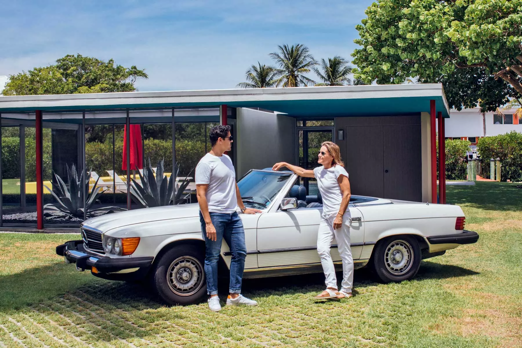 Zwei Personen stehen neben einem weißen Cabrio vor einem modernistischen Haus in Sarasota, Florida