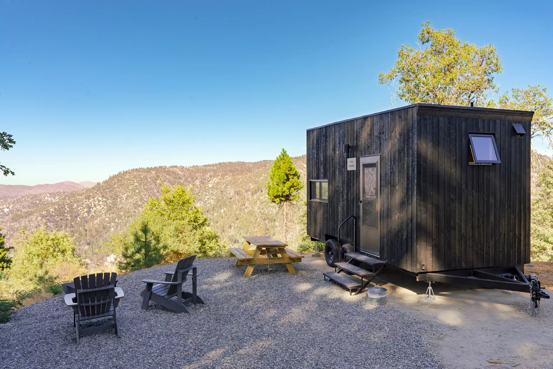 Getaway Cabin eksterieur oan 'e râne fan in útsjoch mei picknicktafel en stuollen