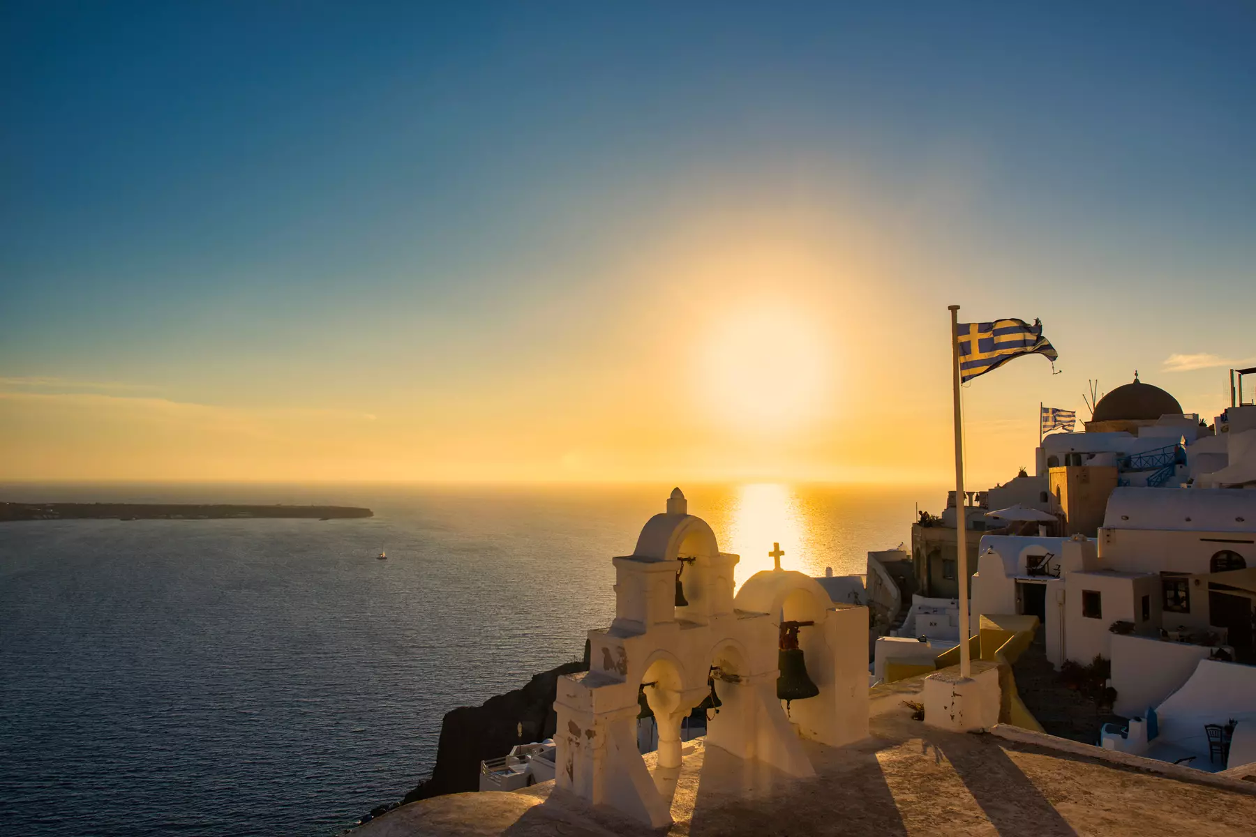 Coucher de soleil derrière les dômes bleus du village d'Oia, Santorin, Grèce