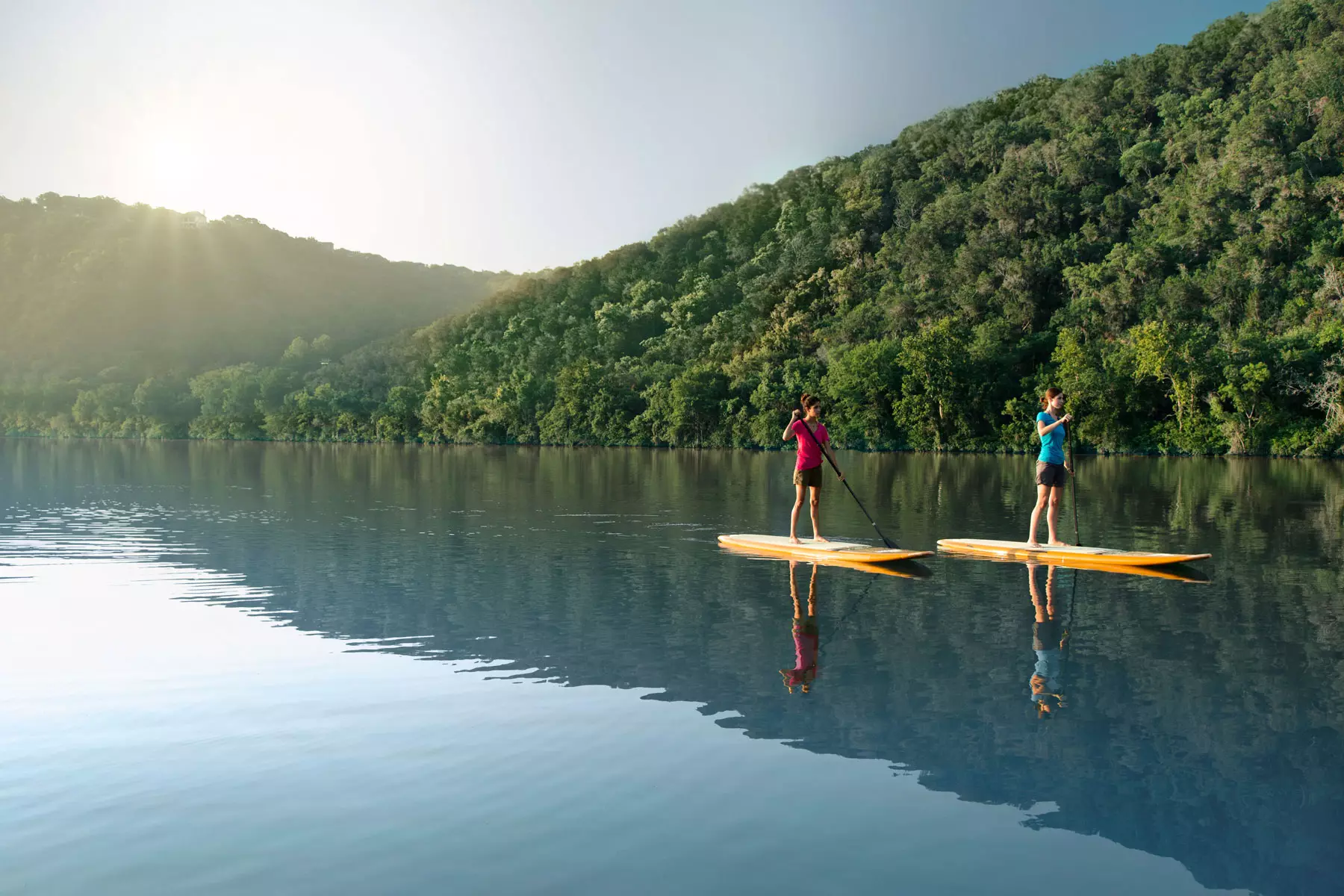 Ob tug paddle boarders ntawm Lake Austin