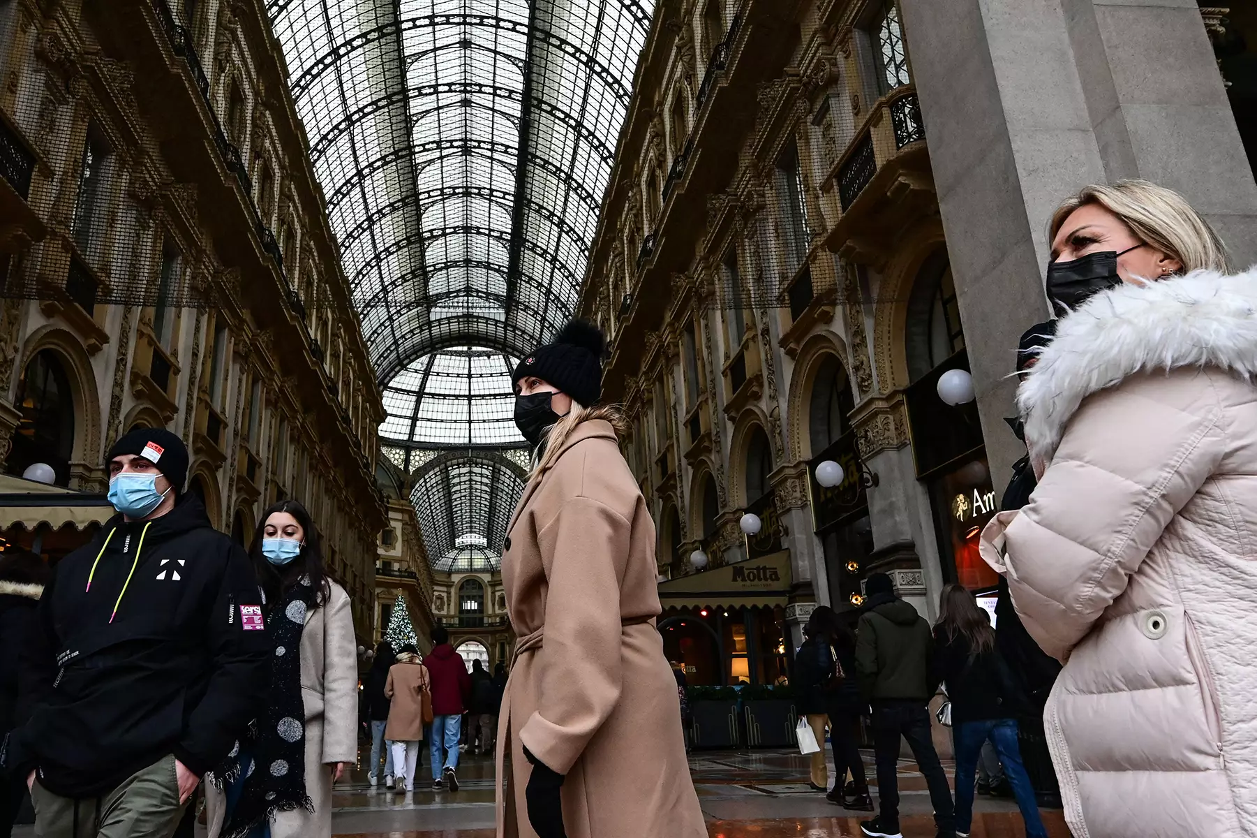 Људи са маскама шетају близу трга Дуомо у Милану, Италија