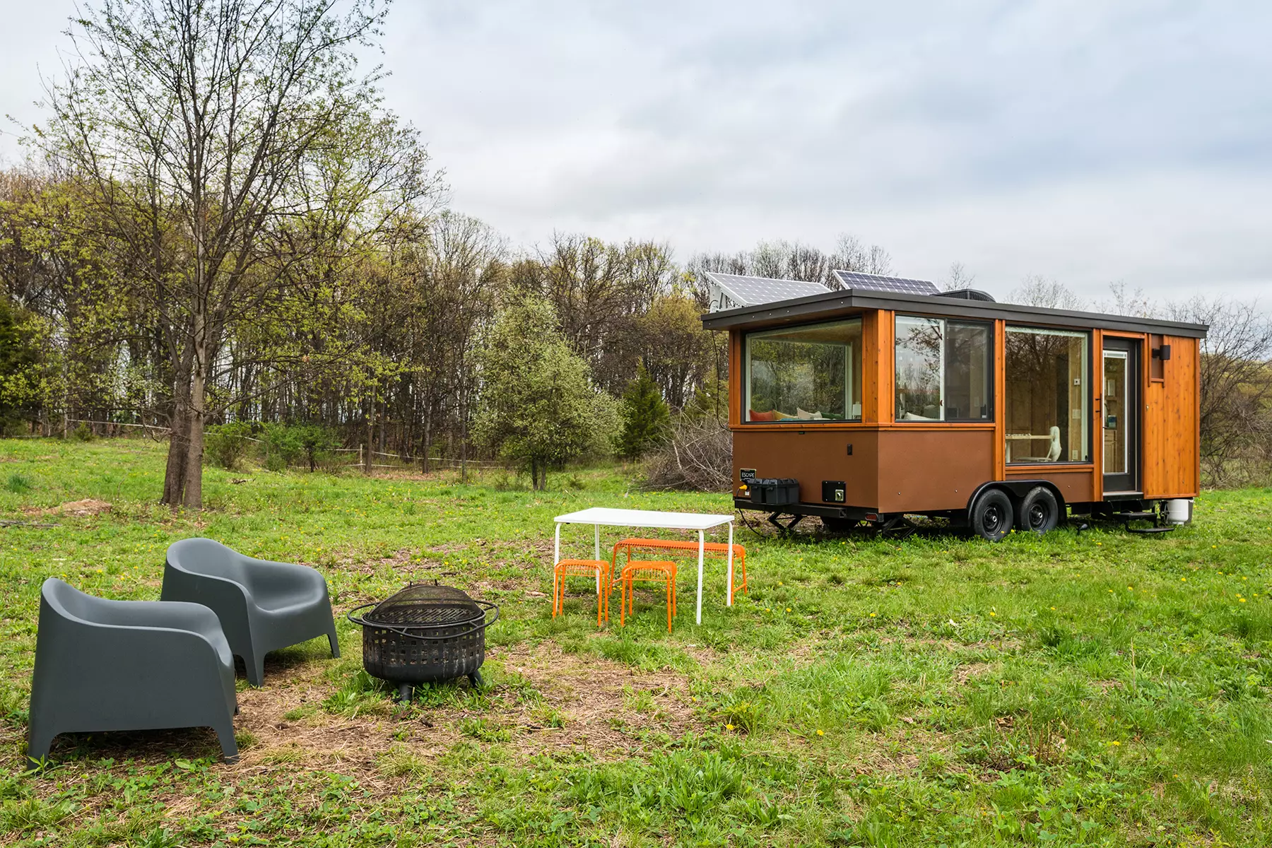 Cadeiras ao redor de uma fogueira do lado de fora da The Glass House: A Hudson Valley Tiny Home Escape