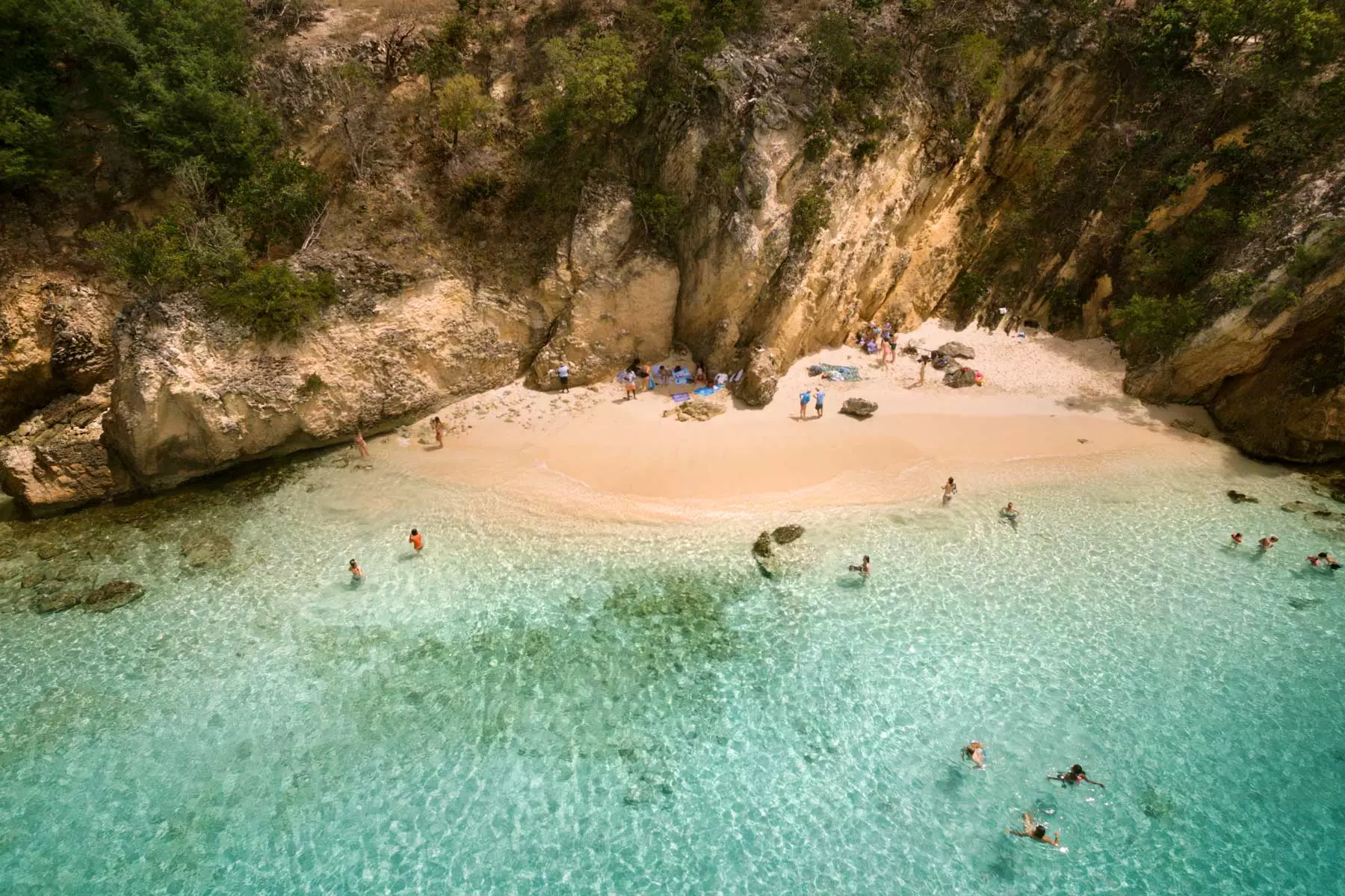 Pemandangan udara dari orang-orang di pantai di bawah tebing terjal di Anguilla