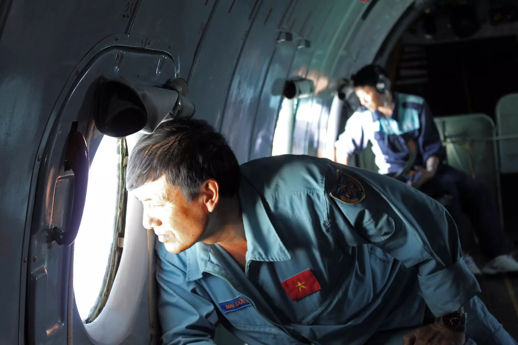 Esta fotografía tomada el 8 de marzo de 2014 muestra al personal militar escaneando el mar a bordo de un avión de la Fuerza Aérea de Vietnam que participa en una misión de búsqueda de un avión desaparecido de Malaysia Airlines, en algún lugar entre la costa este de Malasia y el sur de Vietnam.