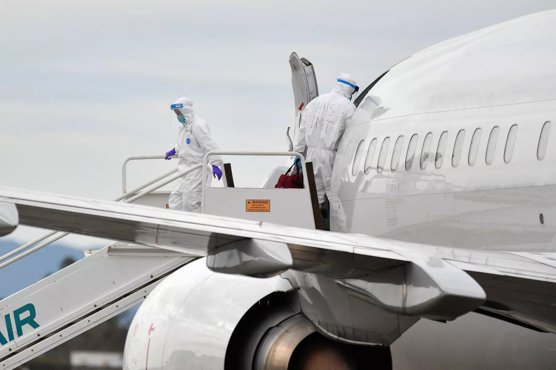 El personal médico ayuda a subir a los pasajeros del crucero Grand Princess a los aviones en el Aeropuerto Internacional de Oakland en Oakland, California, el 10 de marzo de 2020.