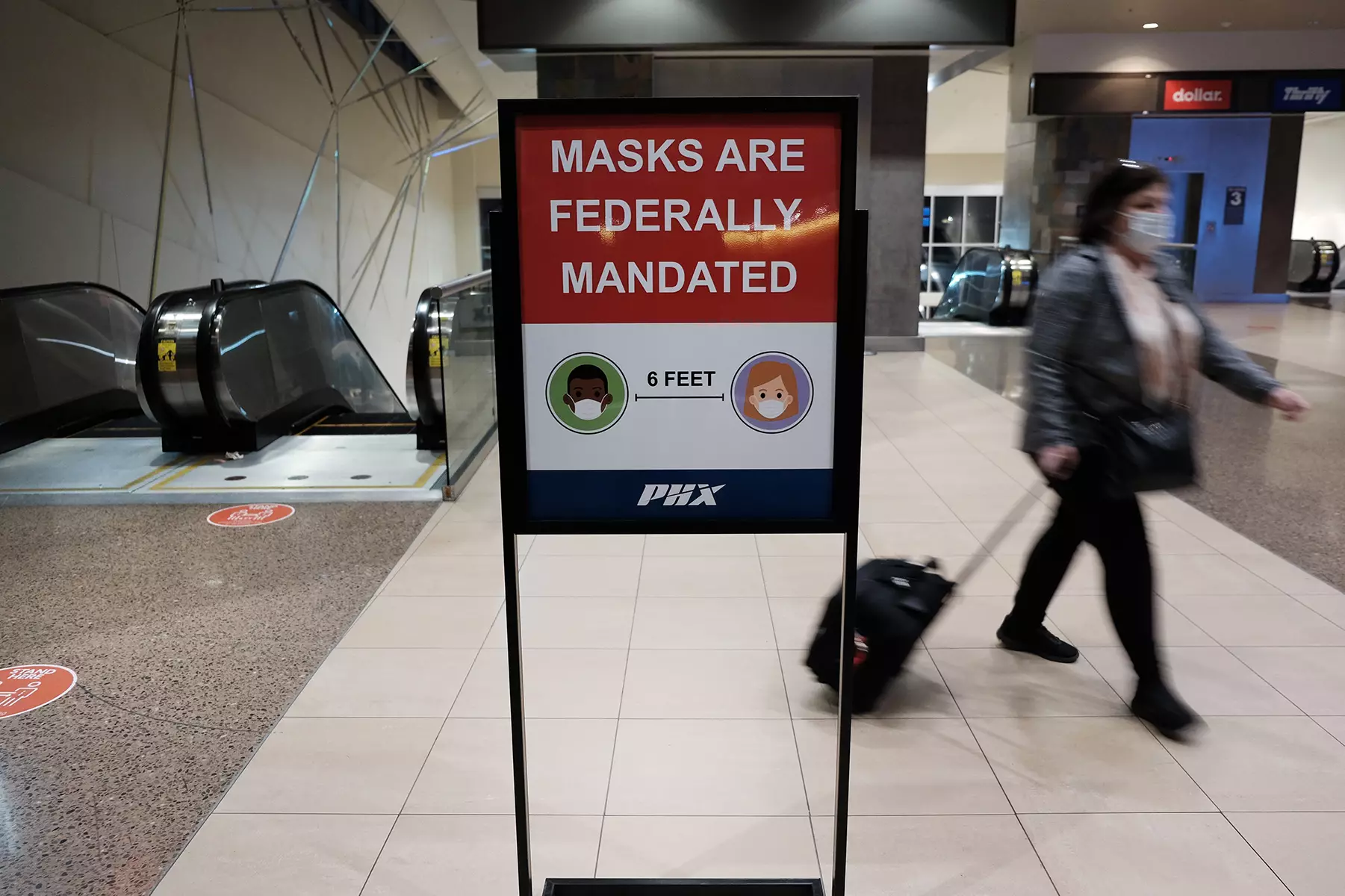 ခရီးသွားများကို သတိပေးသည့် ဆိုင်းဘုတ်တစ်ခုသည် လေဆိပ်တွင် မျက်နှာဖုံးများ တပ်ဆင်ရန် ညွှန်ကြားထားသည်။