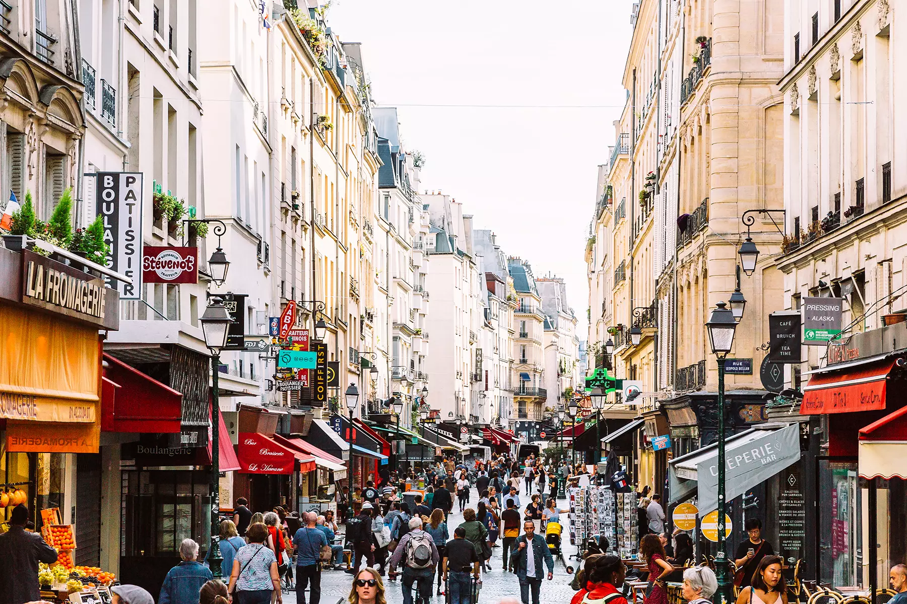 Sluaite daoine ag sráid choisithe Rue Montorgueil i bPáras na Fraince