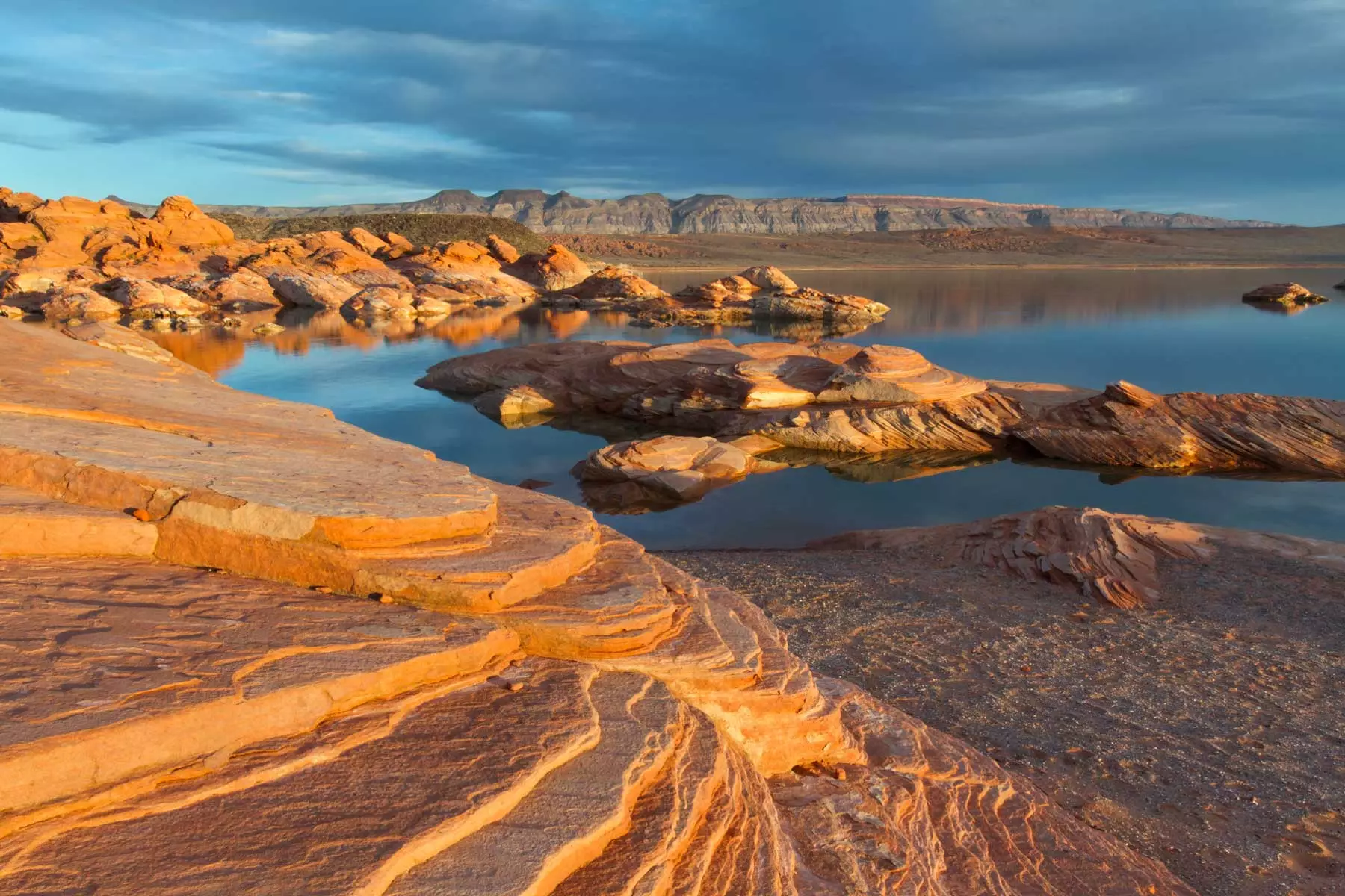 Qırmızı qaya birləşmələri, Sand Hollow Dövlət Parkında, Yutada gün batımı zamanı qumlu çimərlik və göl.